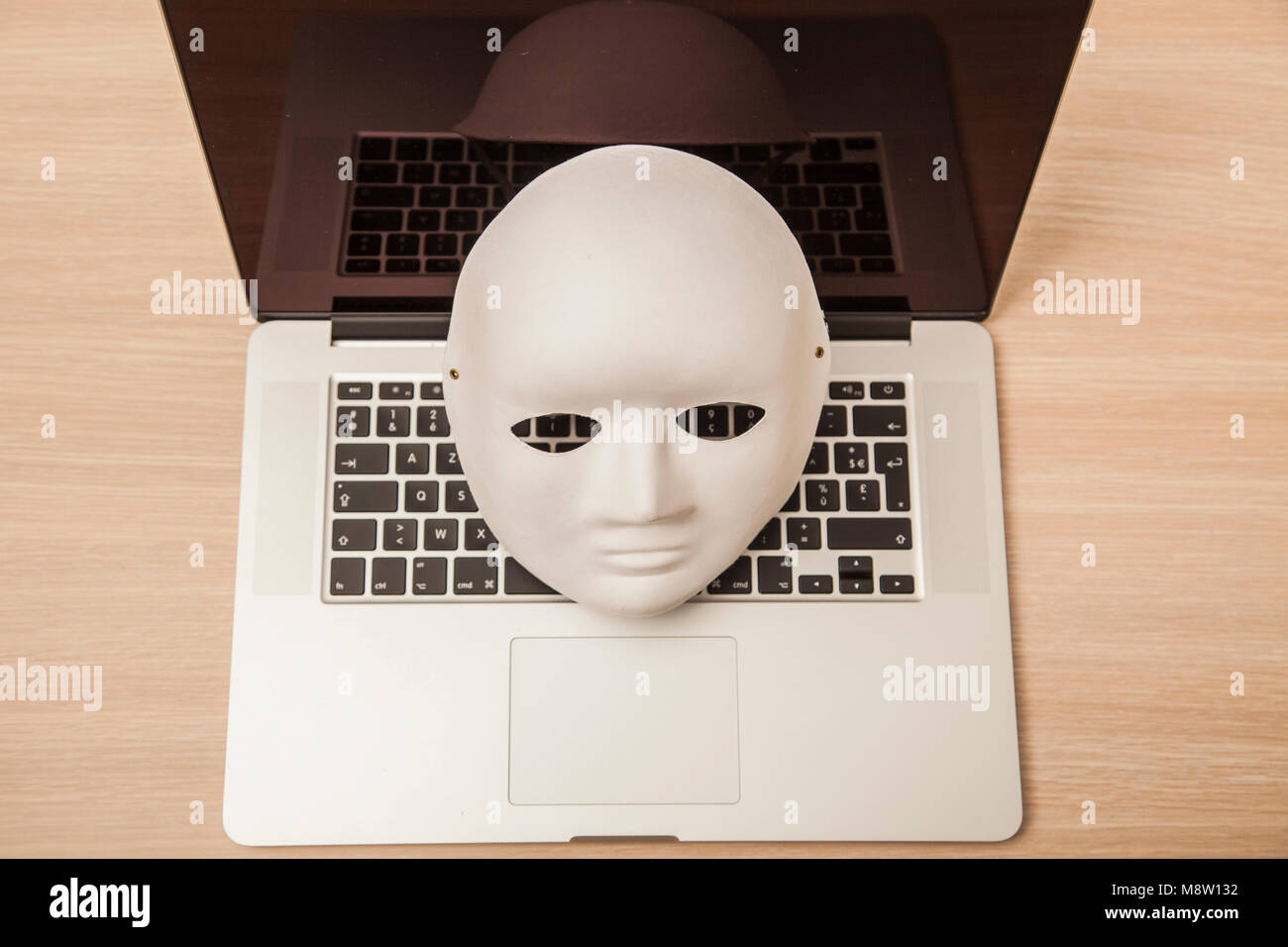 Conceptual photo, mask on a laptop as a symbol of a hacker attack, view ...