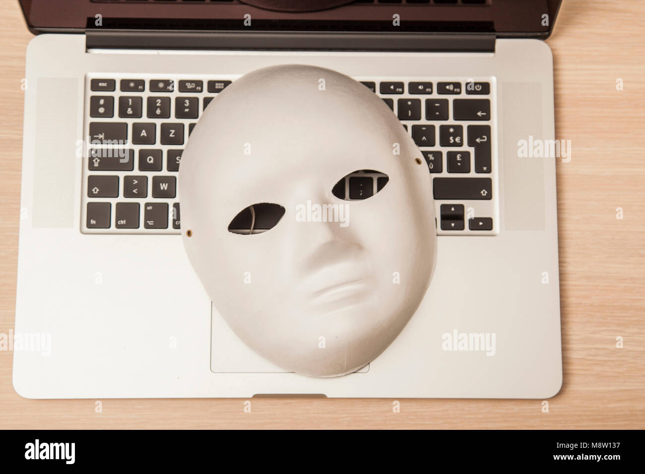 Conceptual photo, mask on a laptop as a symbol of a hacker attack, top ...