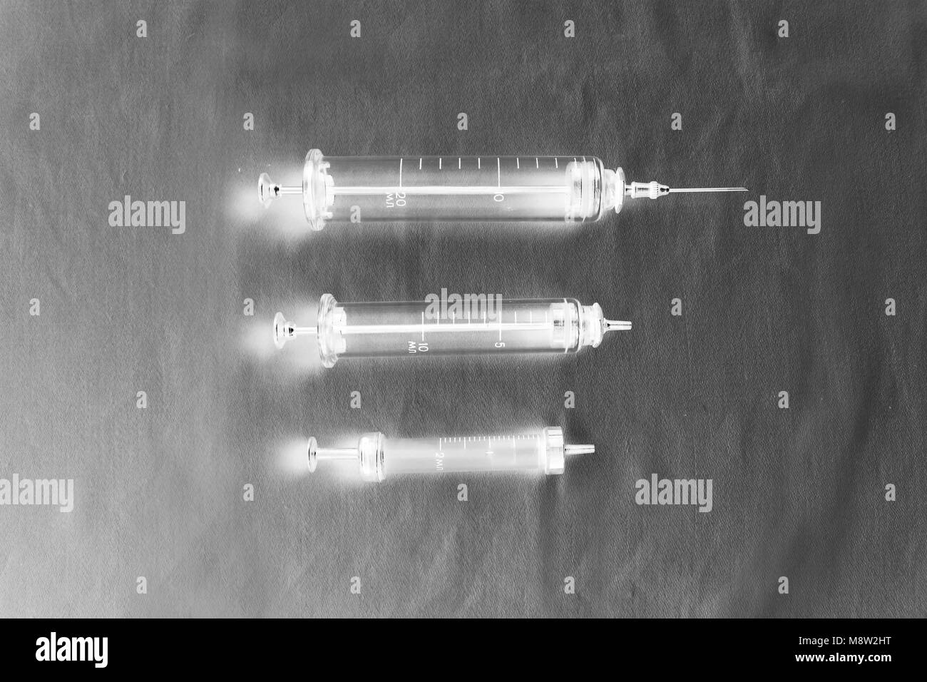 three old medical glass syringes. computer processing, inversion, black ...