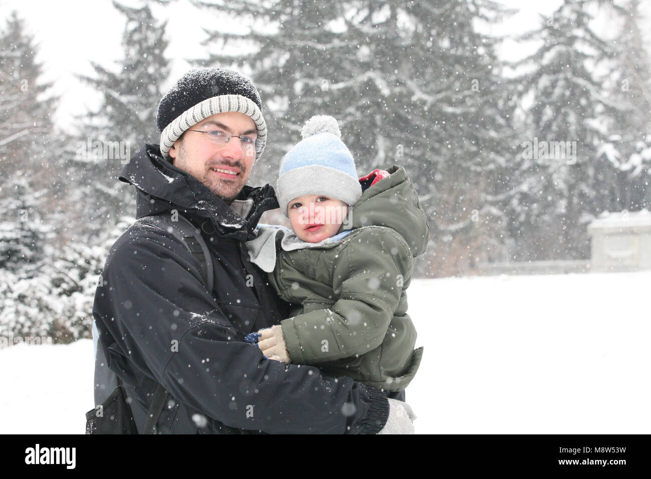 Portrait of an young father, carrying his offspring in a cold winter day Stock Photo - Alamy