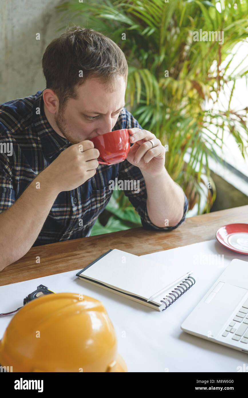 Engineer working in office and drinking coffee Stock Photo - Alamy