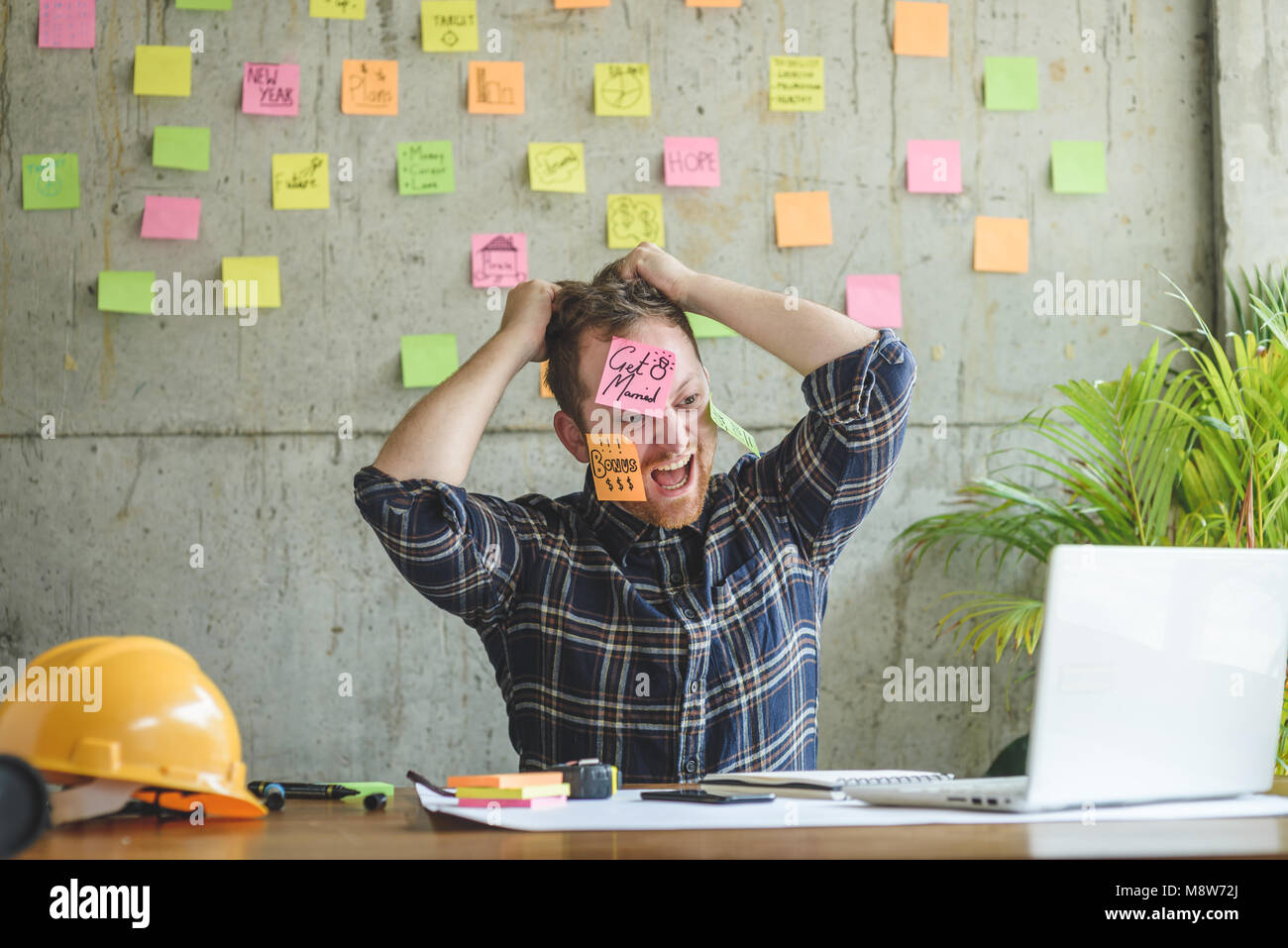 Stressed man with message on sticky notes over his face in office Stock ...