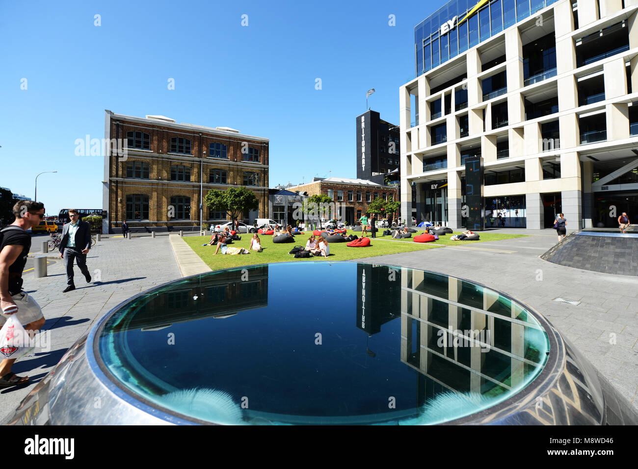 Locals relaxing on the Takutai Lawn at the Talitao square in Auckland's ...