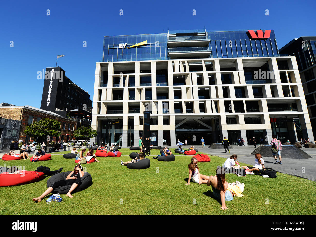 Locals relaxing on the Takutai Lawn at the Talitao square in Auckland's ...