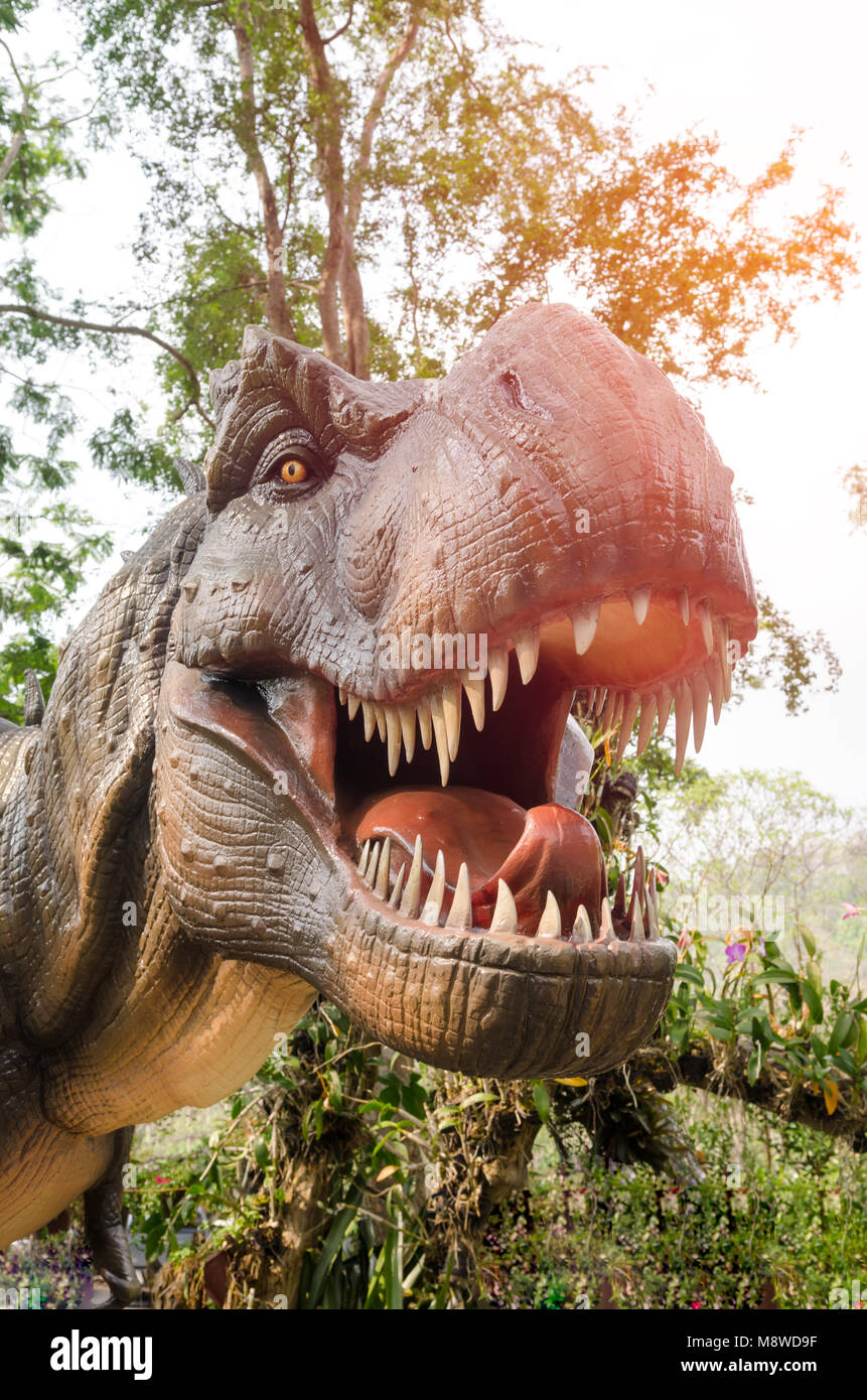 Dinosaur T - rex statue with orange light in nature Stock Photo - Alamy