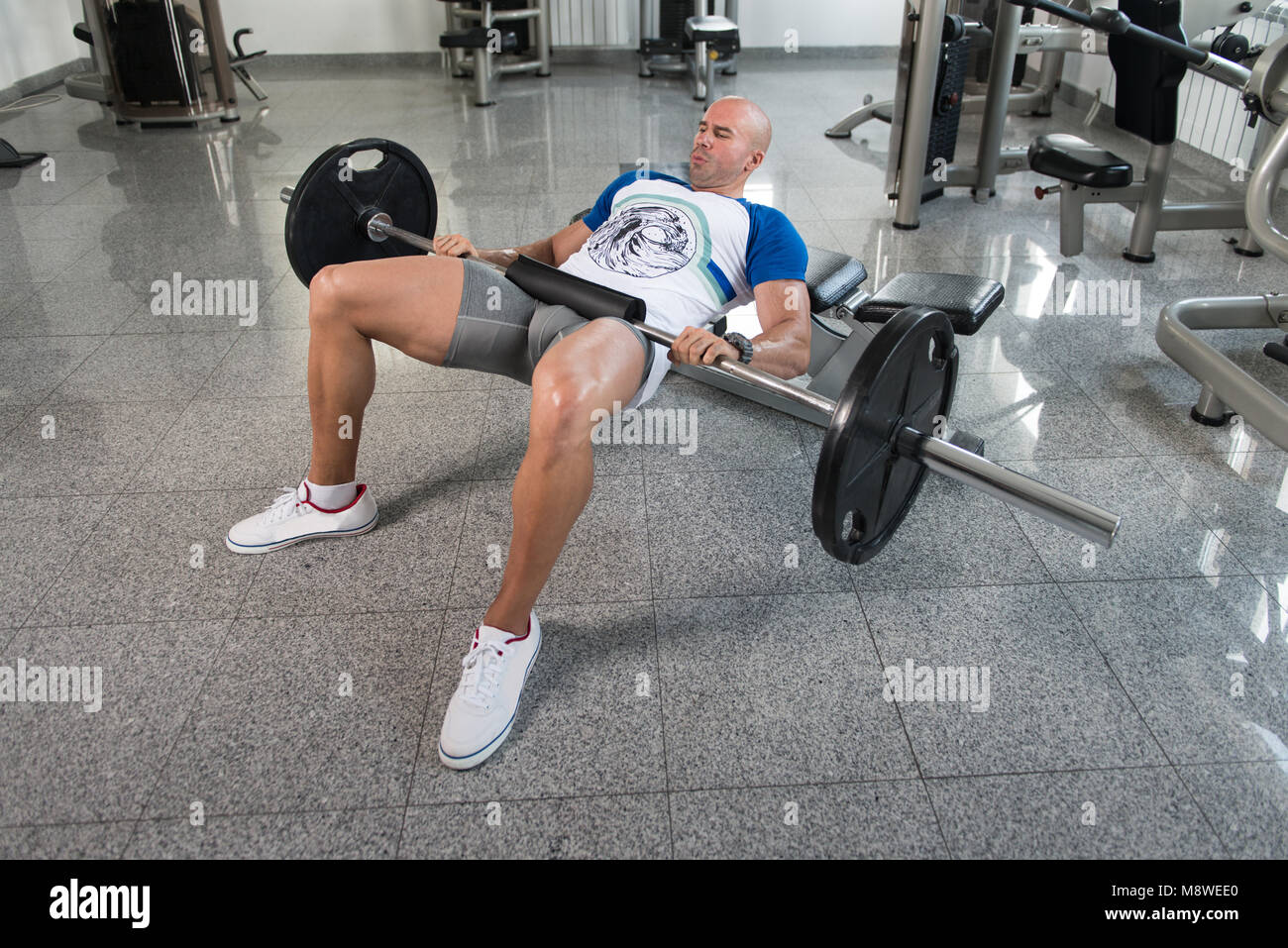 Strong Man In The Gym Exercising Hamstrings With Barbell - Muscular ...