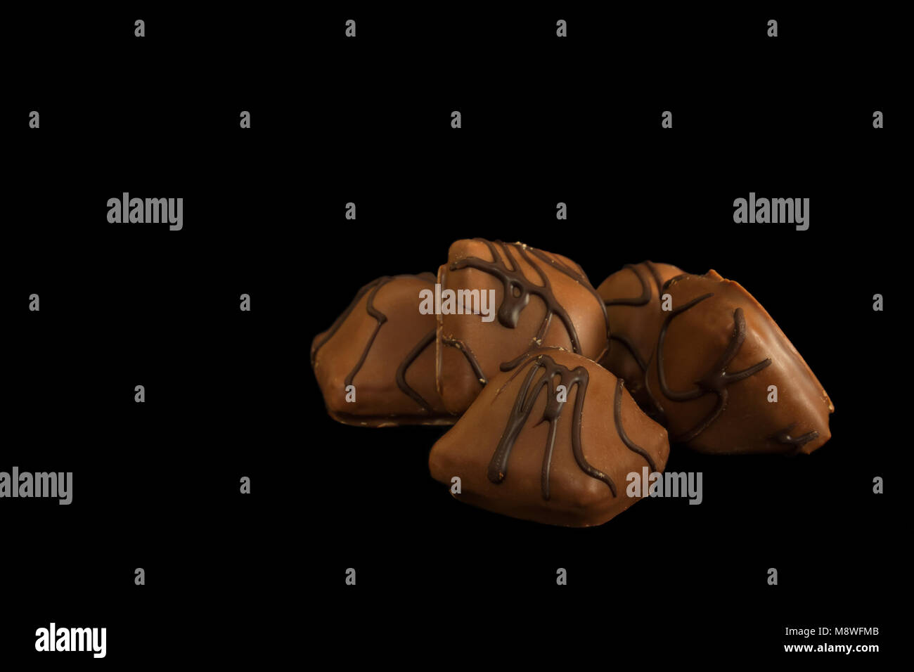 Triangular chocolate candies on a black background. Do not insulate ...