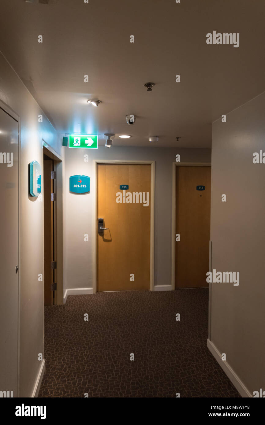 Green emergency exit sign showing the way to escape Stock Photo - Alamy