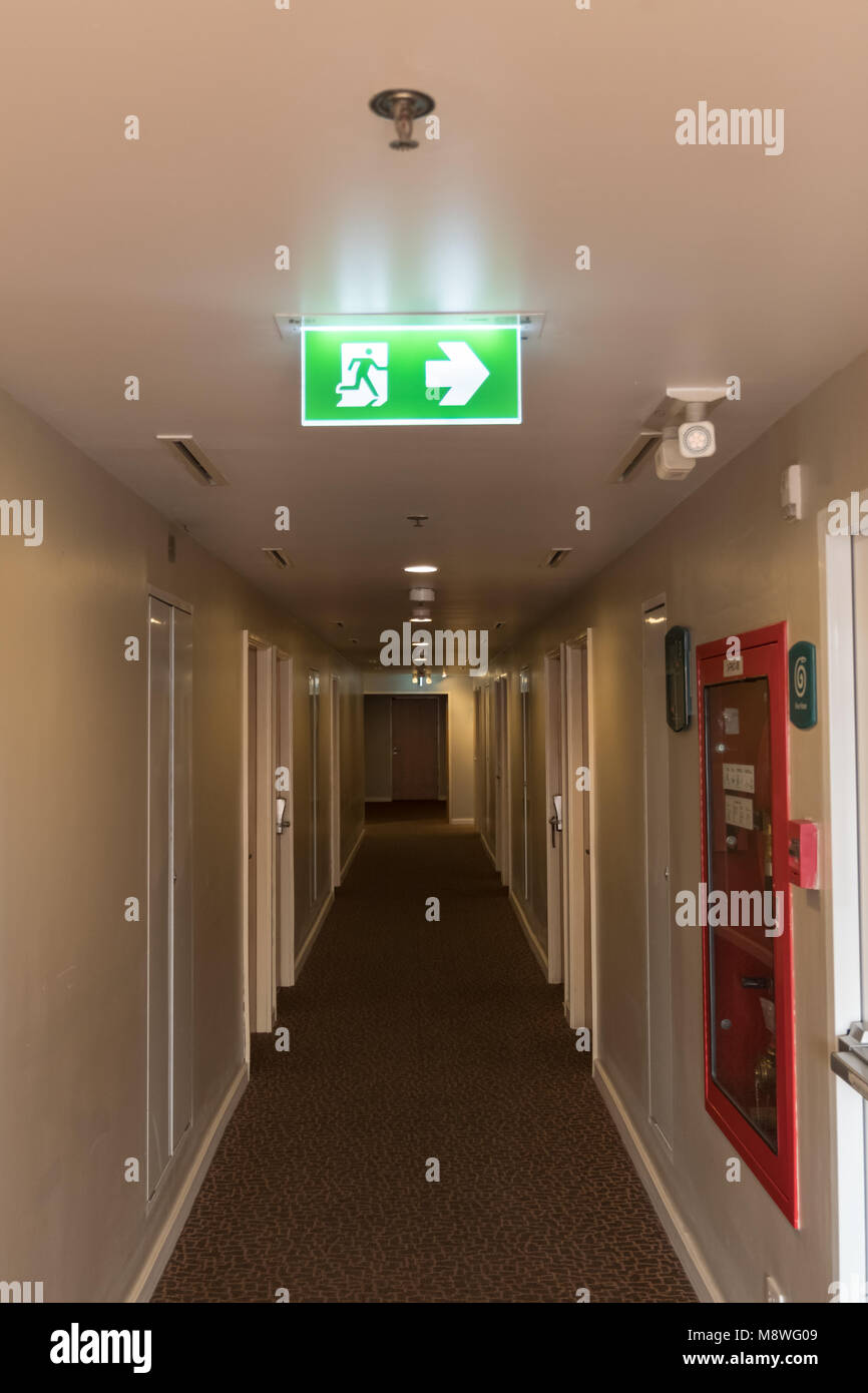 Green emergency exit sign showing the way to escape Stock Photo - Alamy