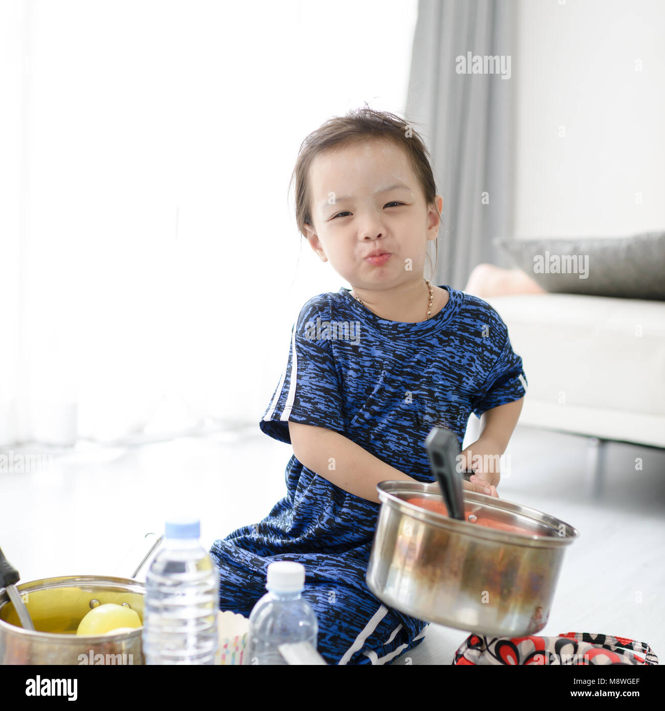 Cute Asian girl playing chef at home Stock Photo - Alamy