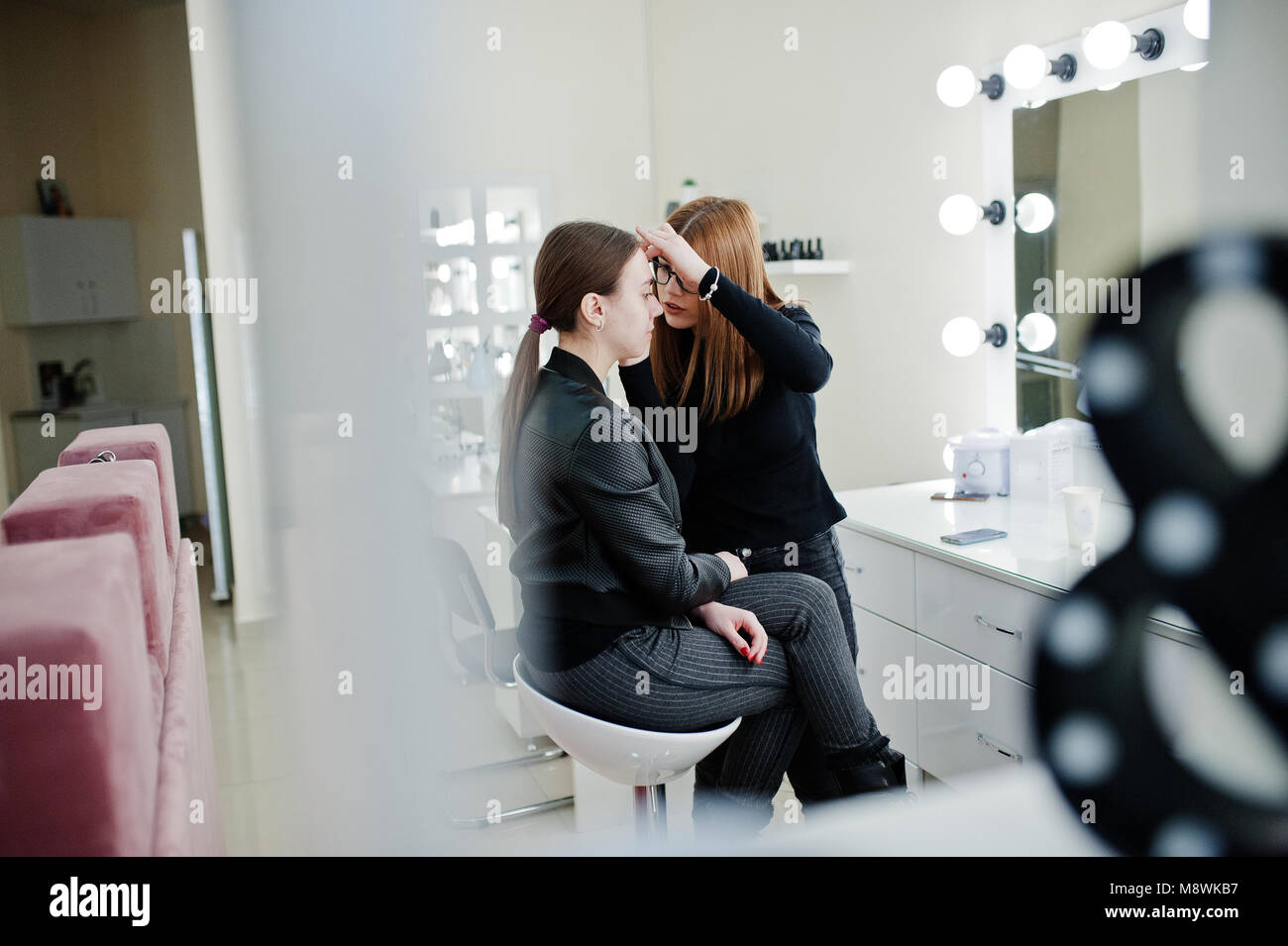 Make up artist work in her beauty visage studio salon. Woman applying ...