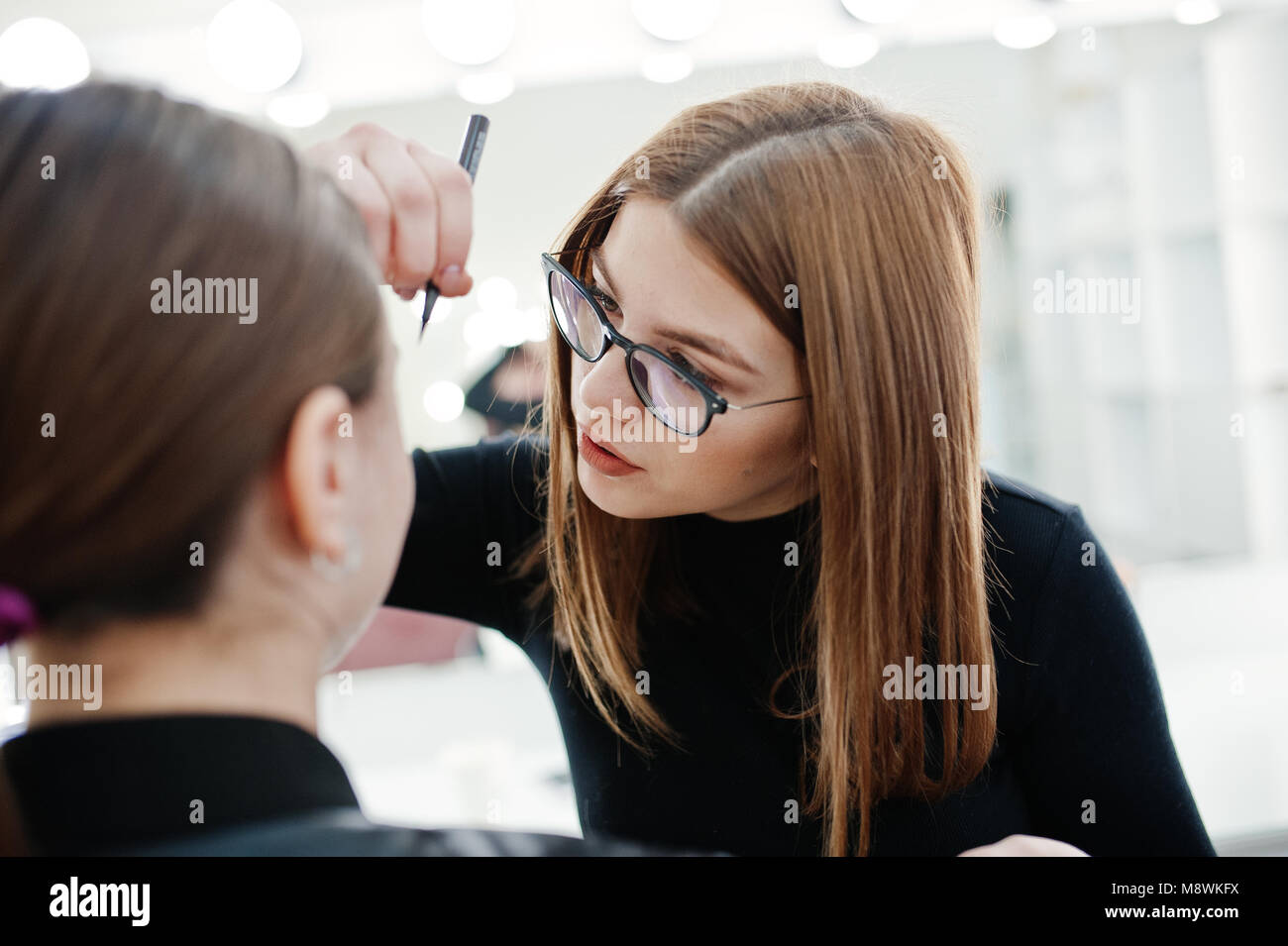 Make up artist work in her beauty visage studio salon. Woman applying ...