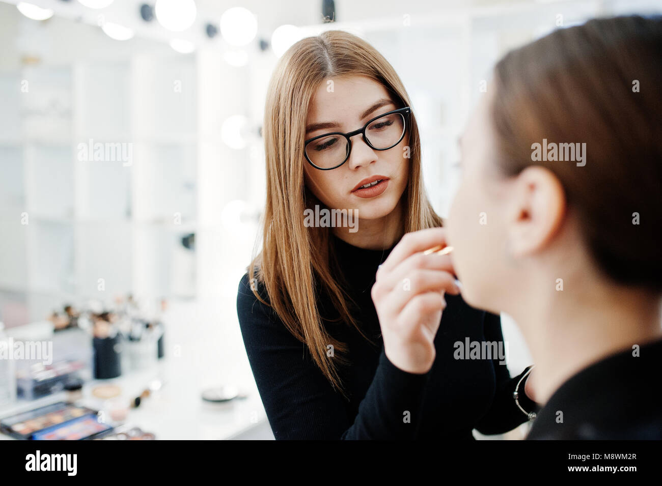 Make up artist work in her beauty visage studio salon. Woman applying ...