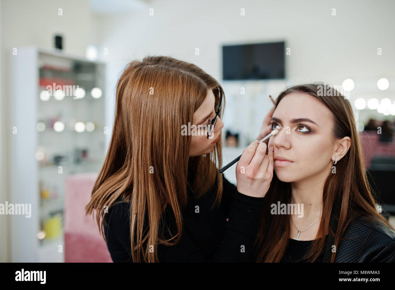 Make up artist work in her beauty visage studio salon. Woman applying ...