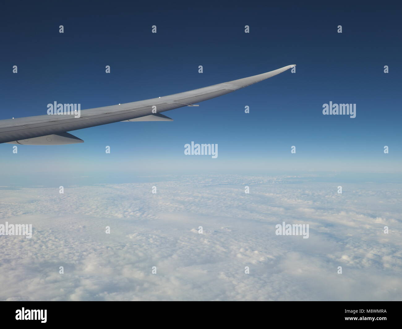 Panoramic view on wing and blue sky and cloud as seen through window of ...