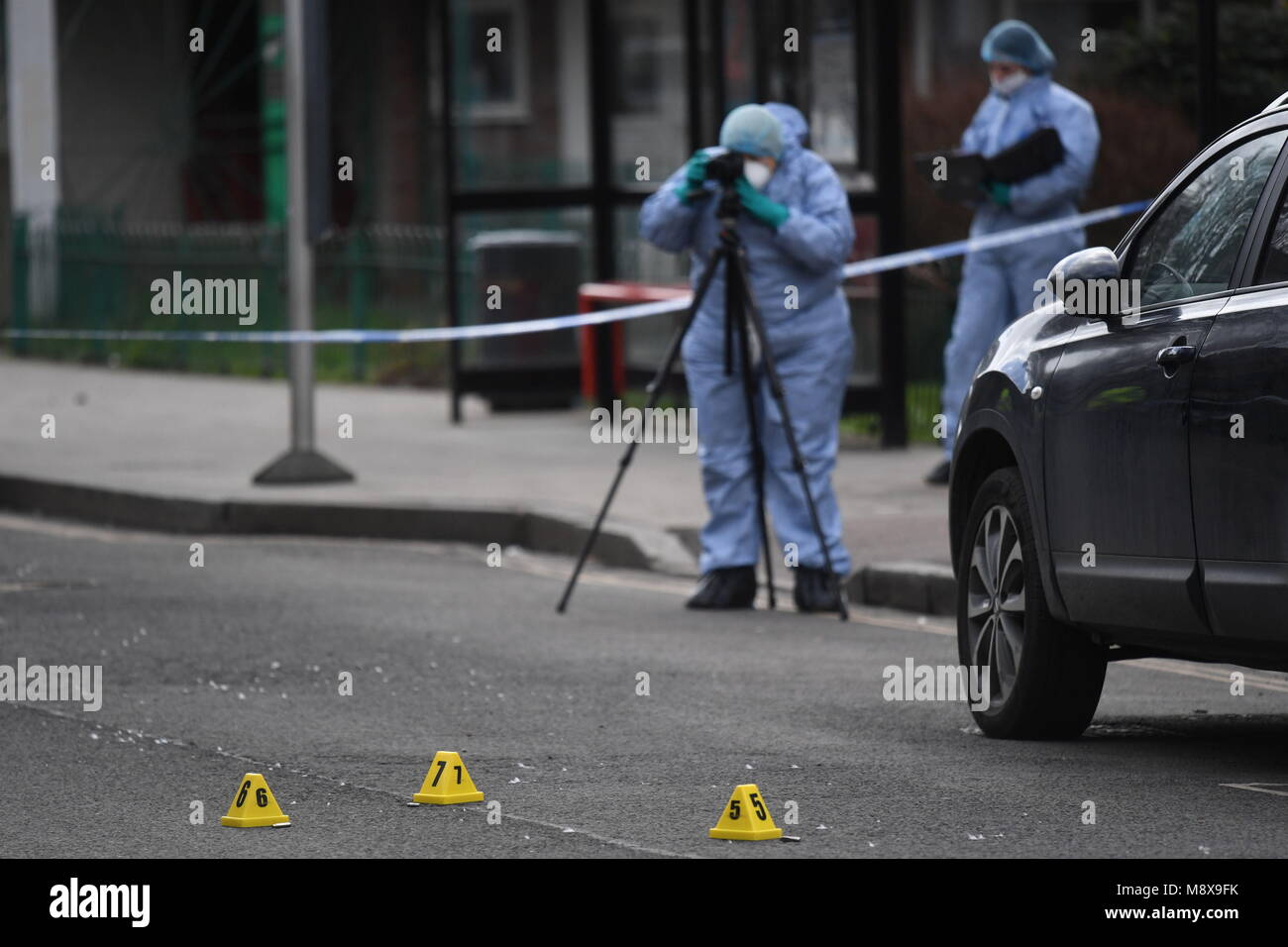 A forensic officer photographs cartridges in Mandeville Street, Clapton ...