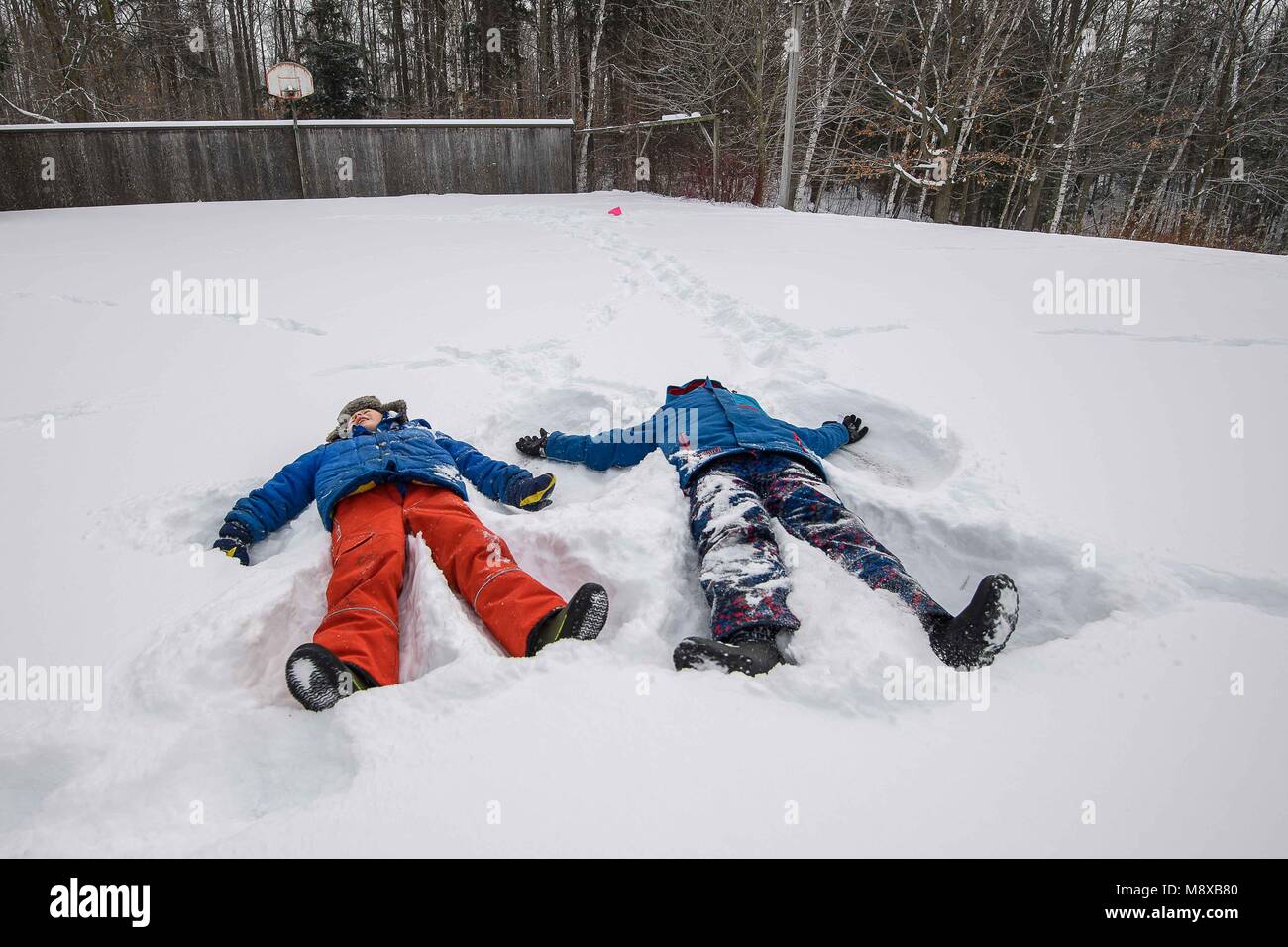 Boys making snow angels Stock Photo - Alamy