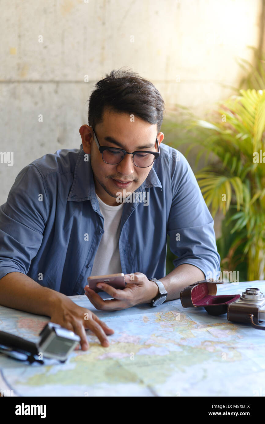 Asian tourist looking at worldmap and plans for his new trip Stock ...