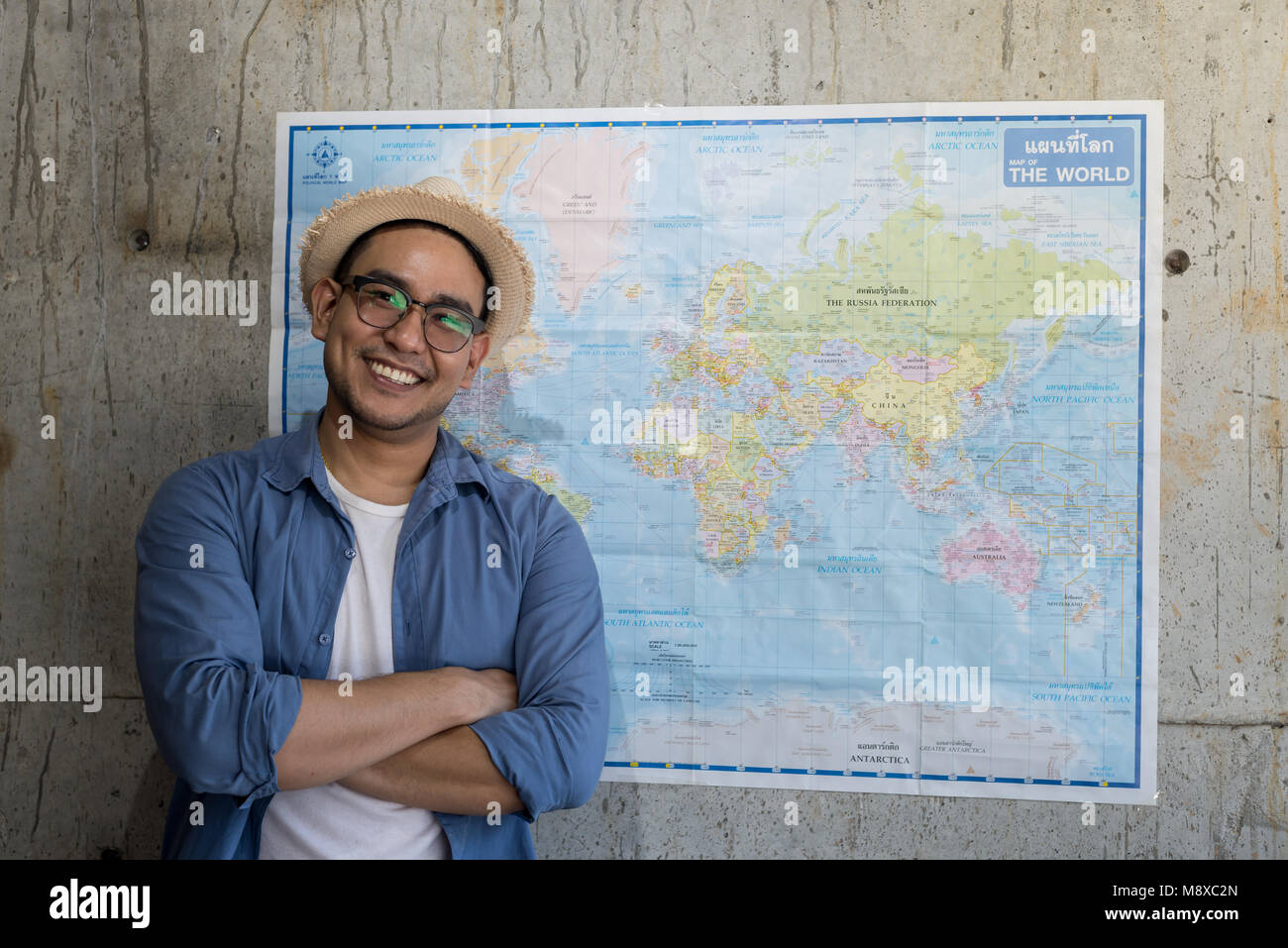 Tourist standing with worldmap on wall, plans for next destination ...