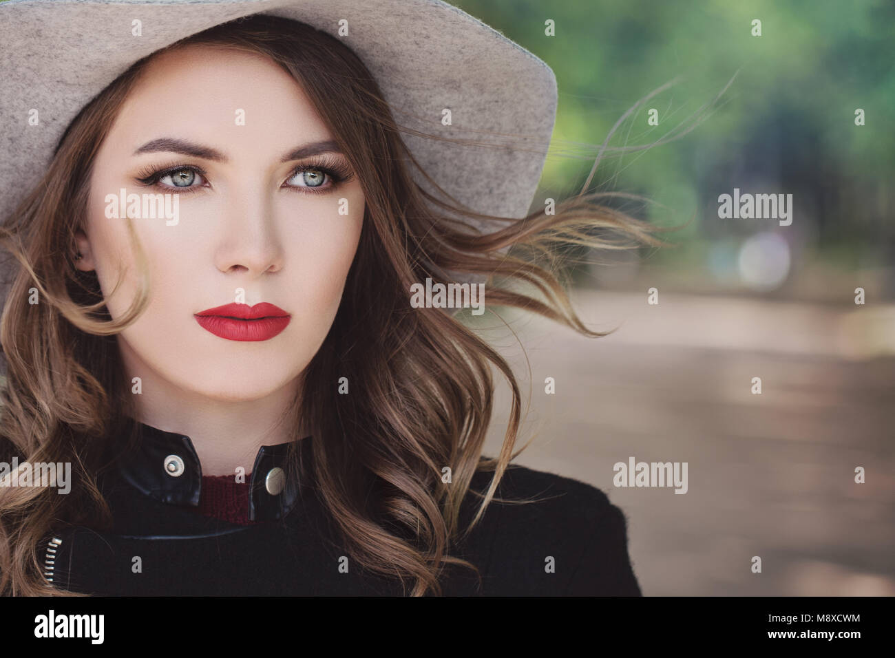 Gorgeous Model Woman in a Hat Outdoors. Windy Curly Hair and Makeup ...