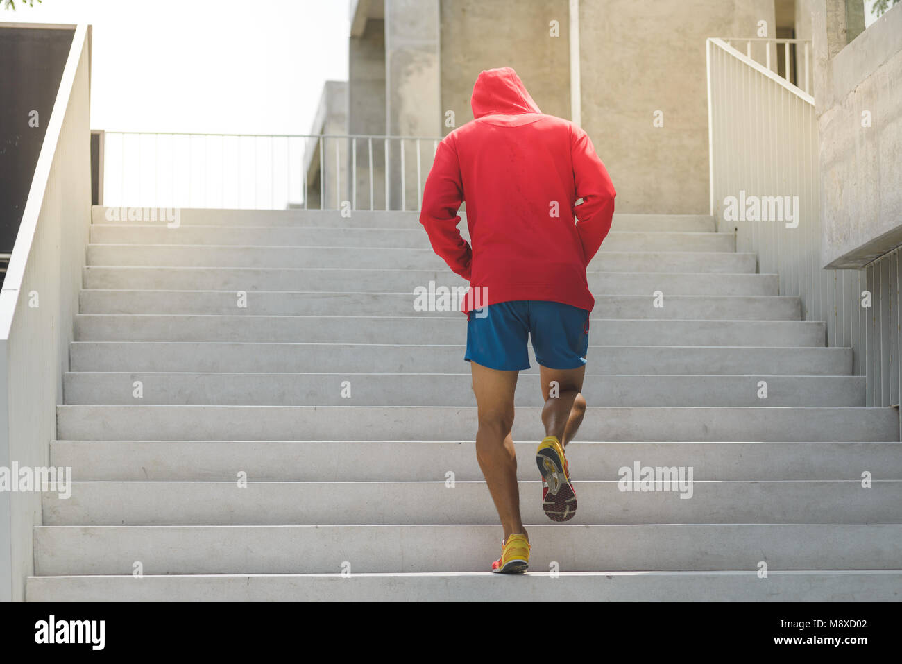 Urban athlete running upstairs. Sporty man working out outside and ...