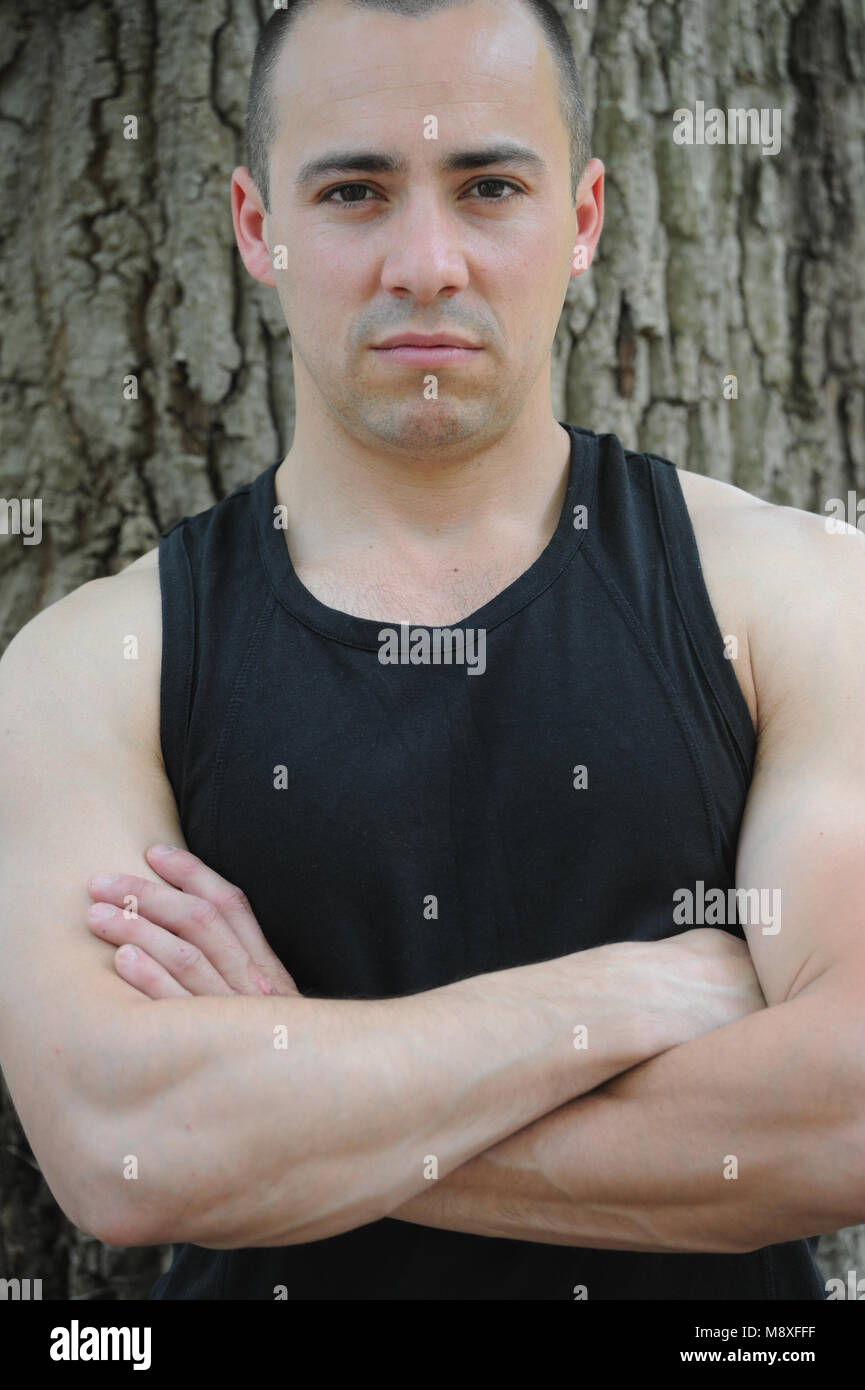 Young man muscular crossing arms in forest Stock Photo - Alamy