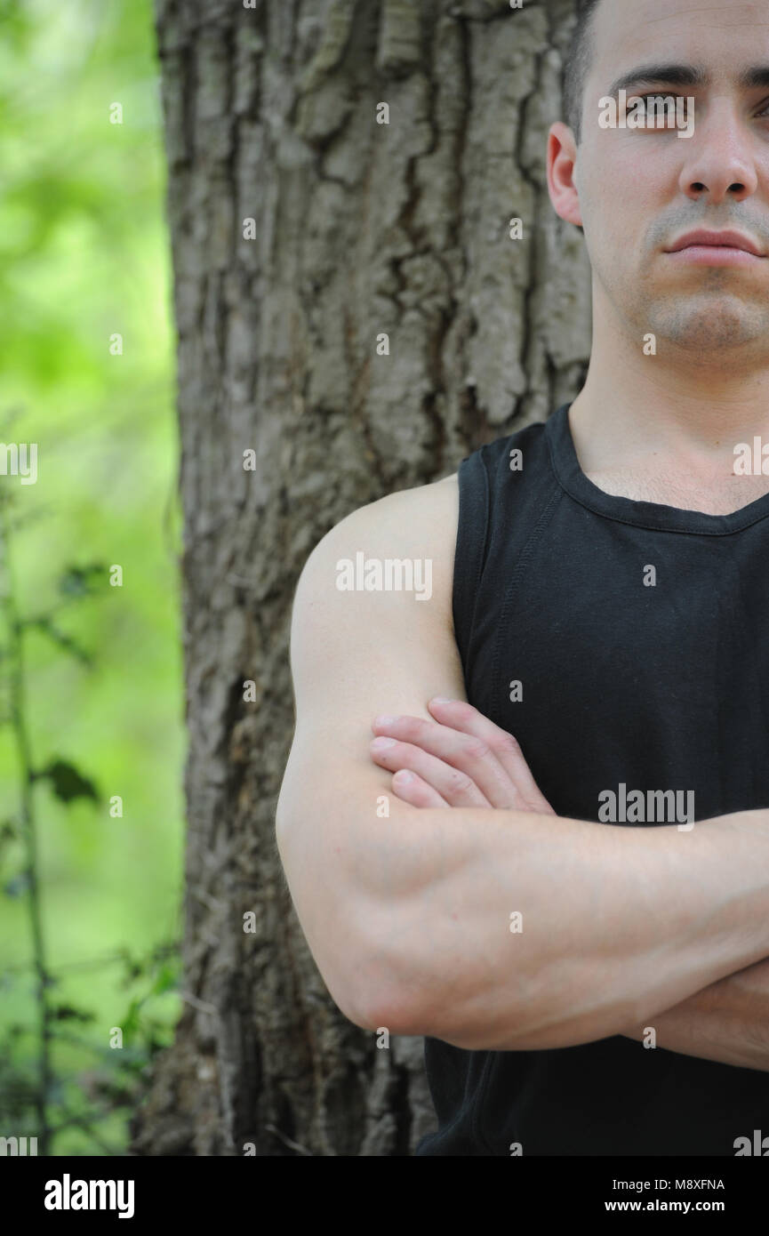 Young man muscular crossing arms in forest Stock Photo - Alamy