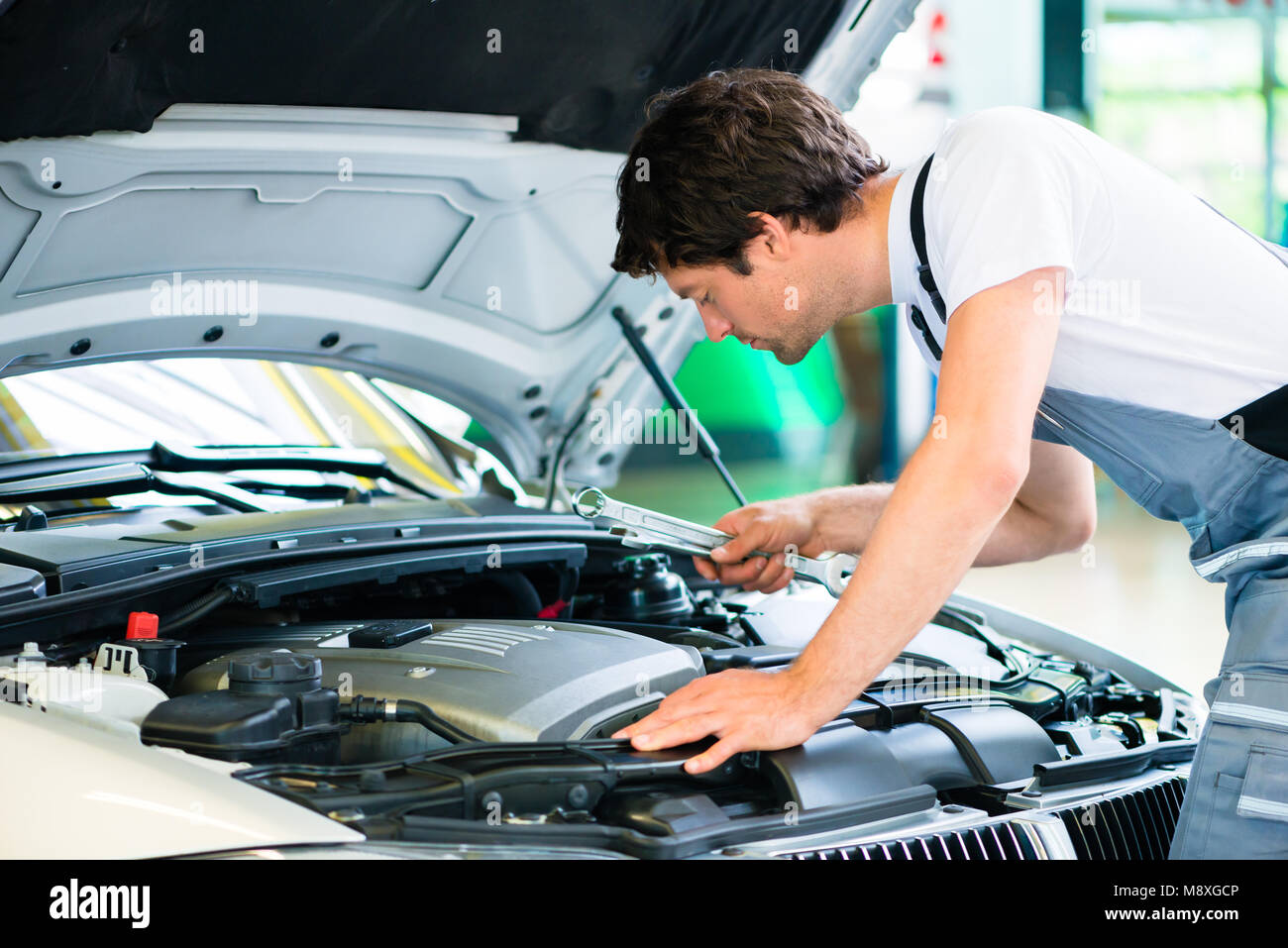 Auto mechanic working in car service workshop Stock Photo - Alamy