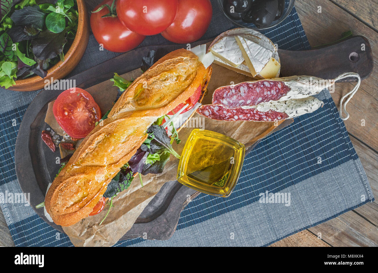 Sandwich with lettuce, slices of fresh tomato, Italian salami ham and ...