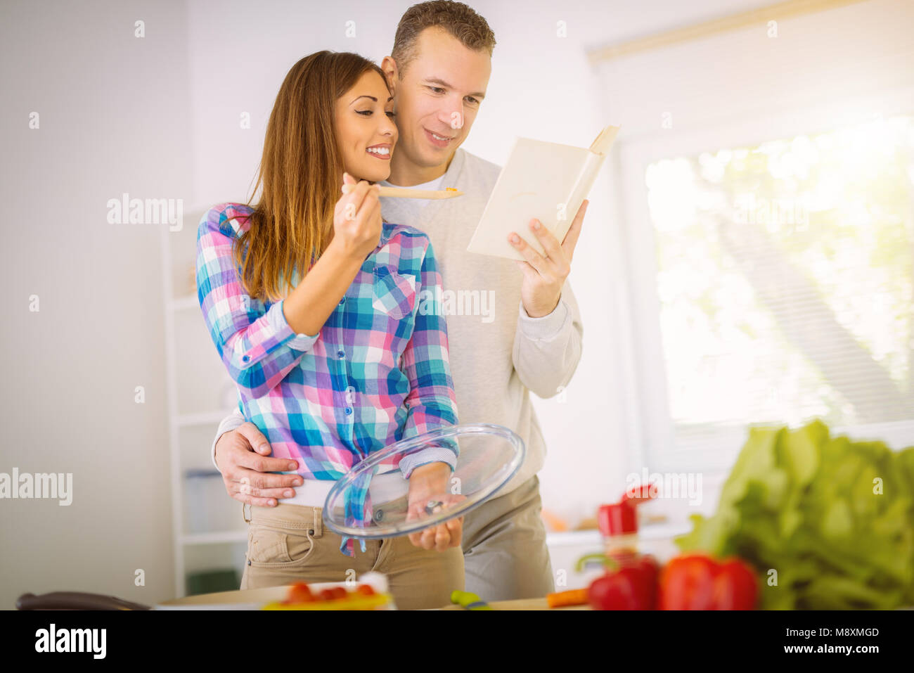 Beautiful young couple cooking healthy meal in the domestic kitchen ...