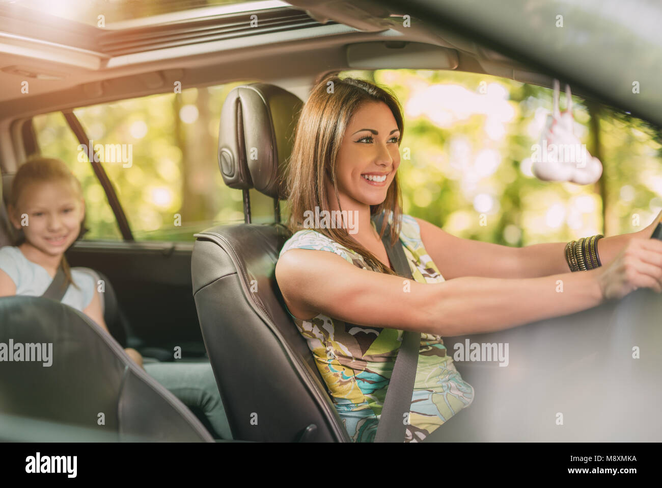 Young beautiful woman with a nice smile driving a car. Her cute ...