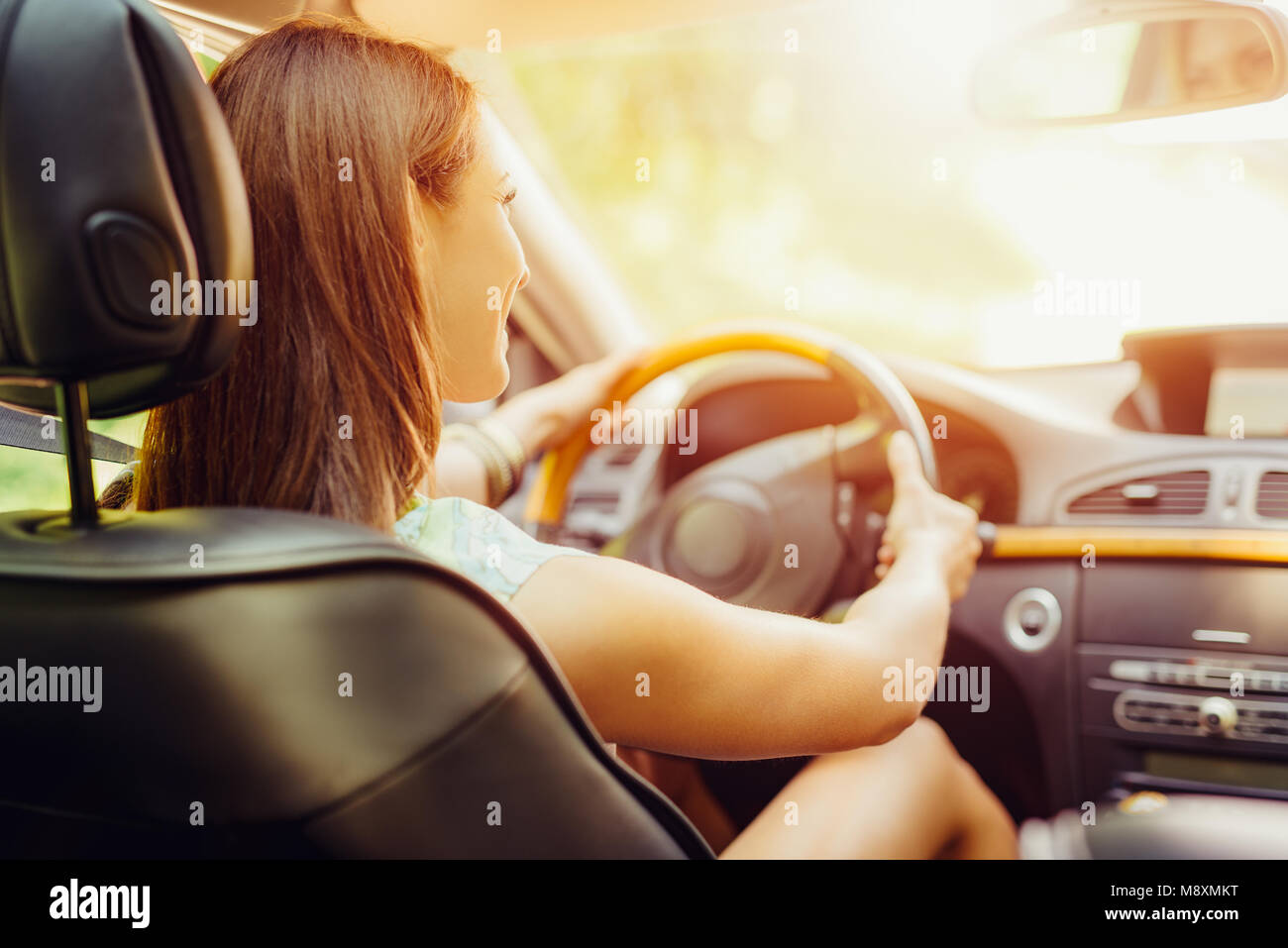 Young beautiful girl with a nice smile driving a car. Rear view Stock ...