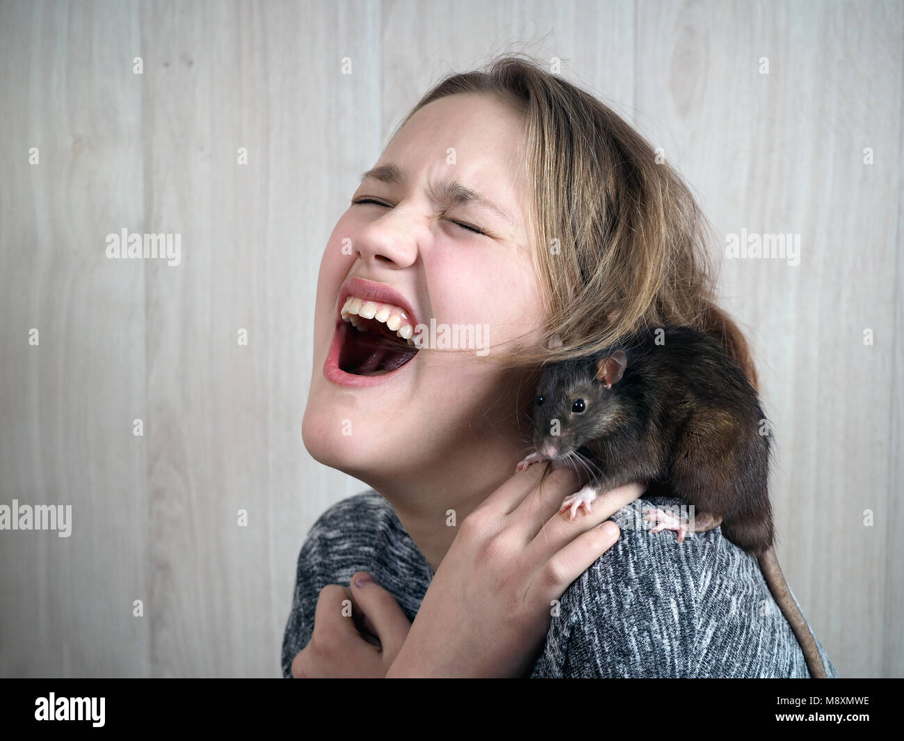 Girl in horror shouts. On a shoulder girls rat. Stunningly emotional ...