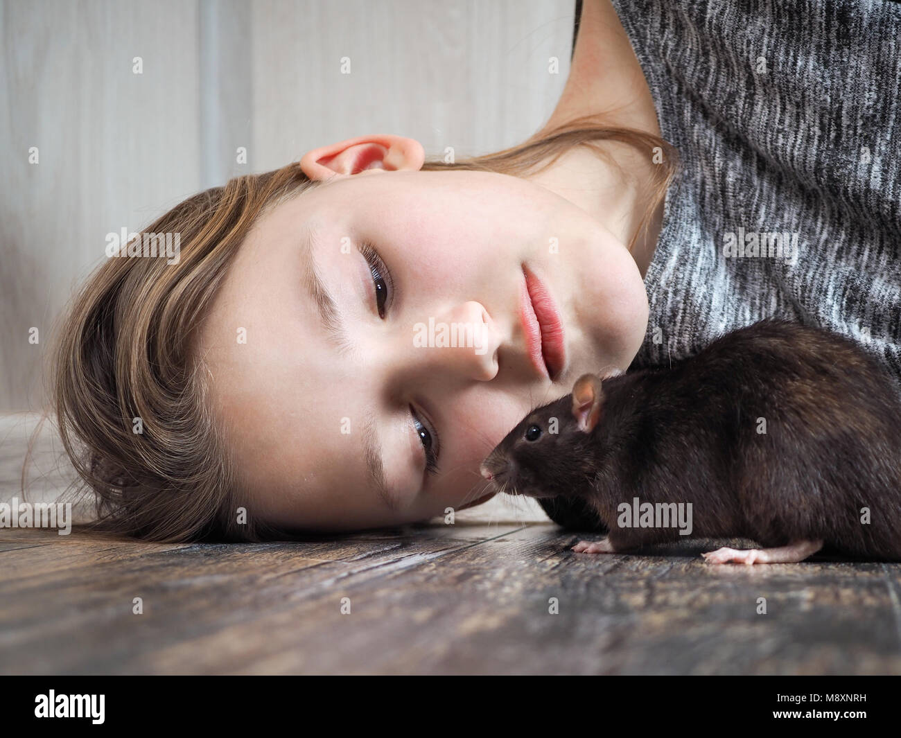 The girl lying on the floor looks at the rat Stock Photo - Alamy