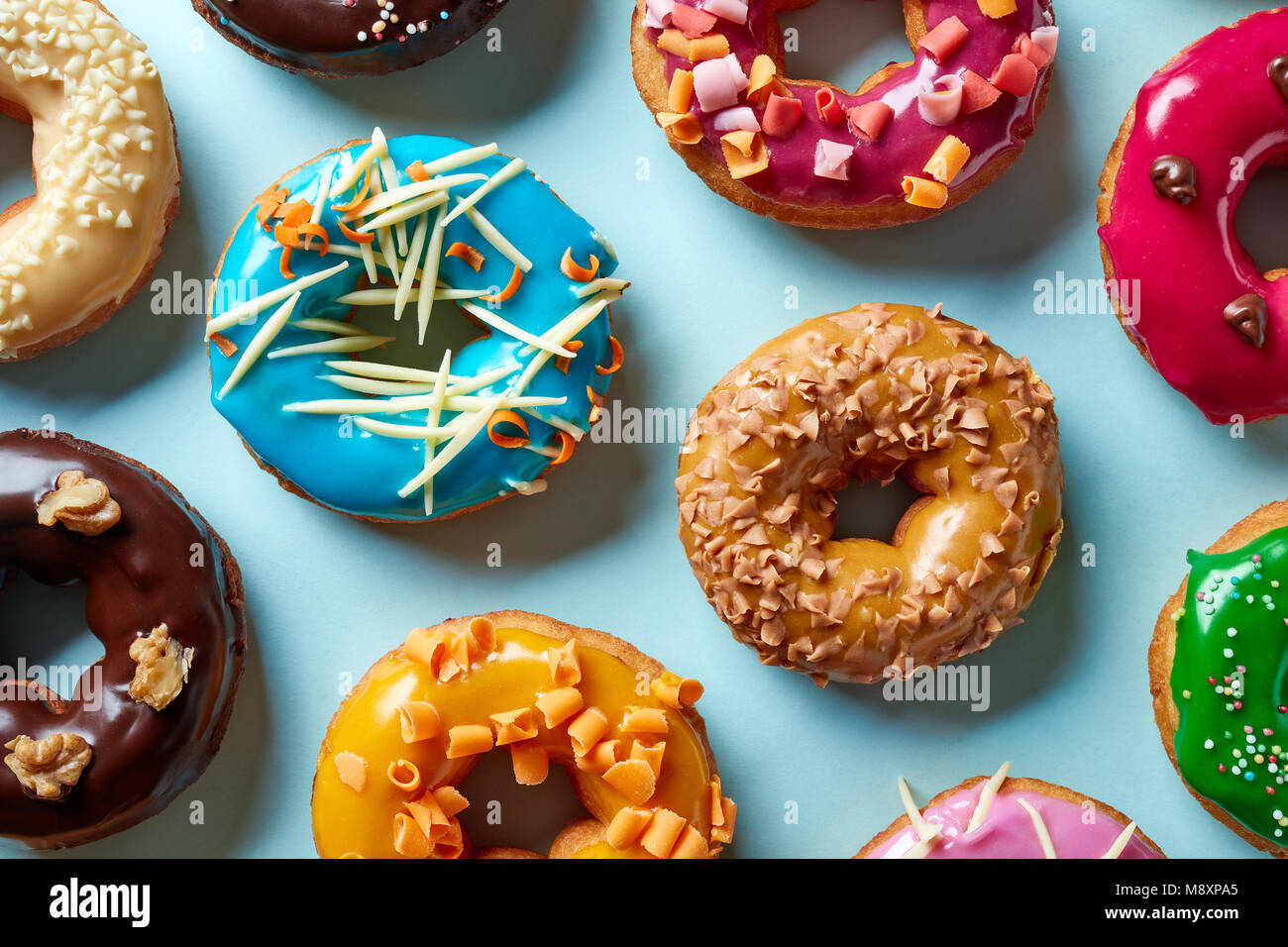 Various colorful donuts on blue background, top view Stock Photo - Alamy