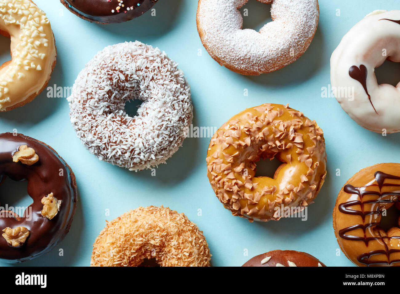 Various colorful donuts on blue background, top view Stock Photo - Alamy