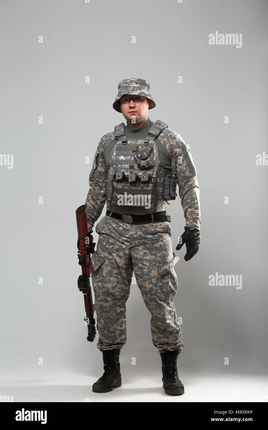 Full-length picture of military man in helmet with gun Stock Photo - Alamy