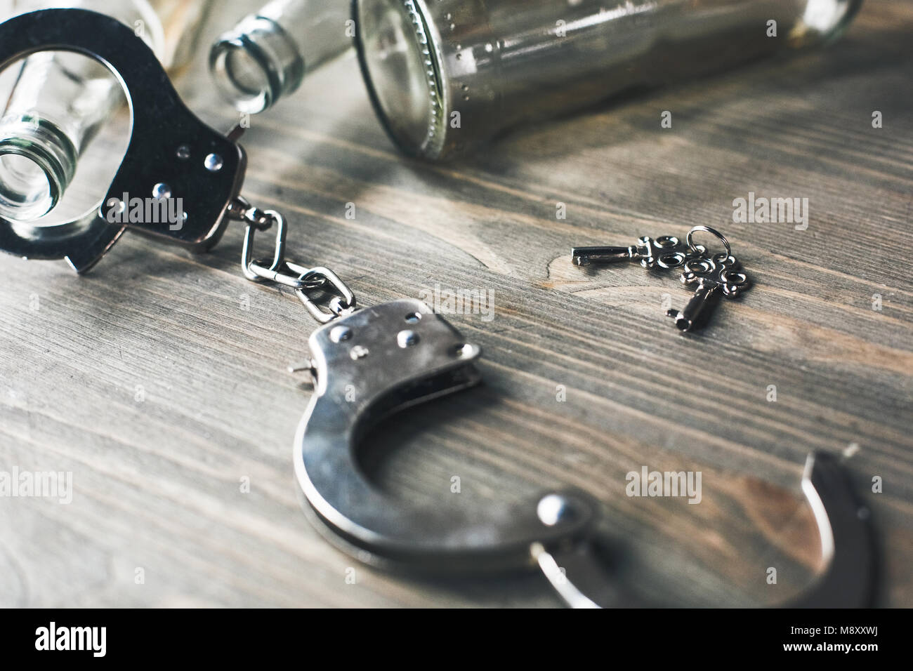 Alcohol addiction objects isolated on table no people opened handcuffs ...