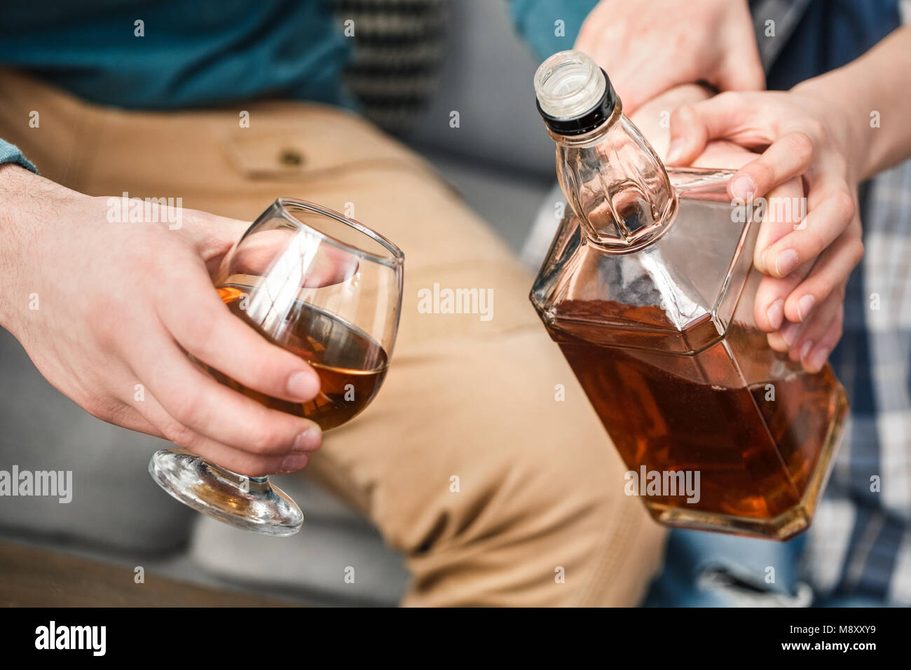 Boy and father alcoholic at home son stopping dad fron drinking whiskey ...