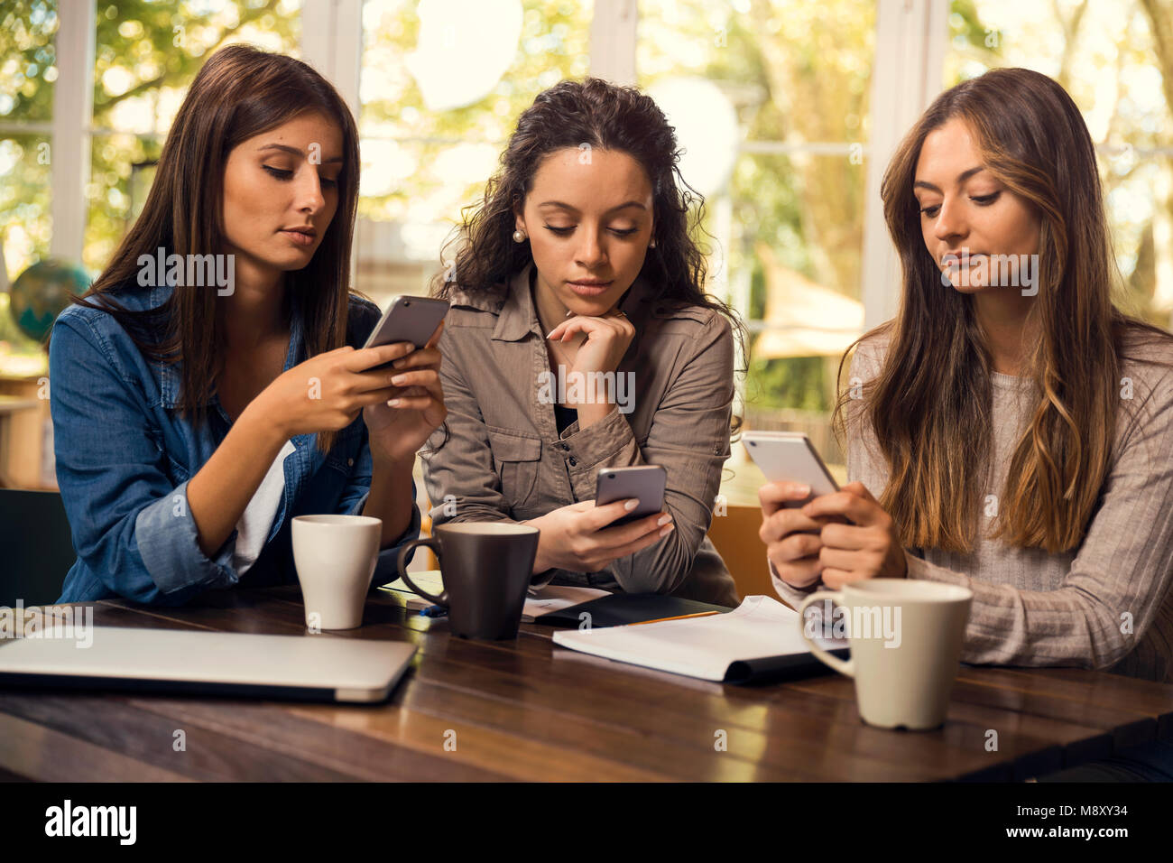 Group of girls with attention on the phone instead of studies Stock ...