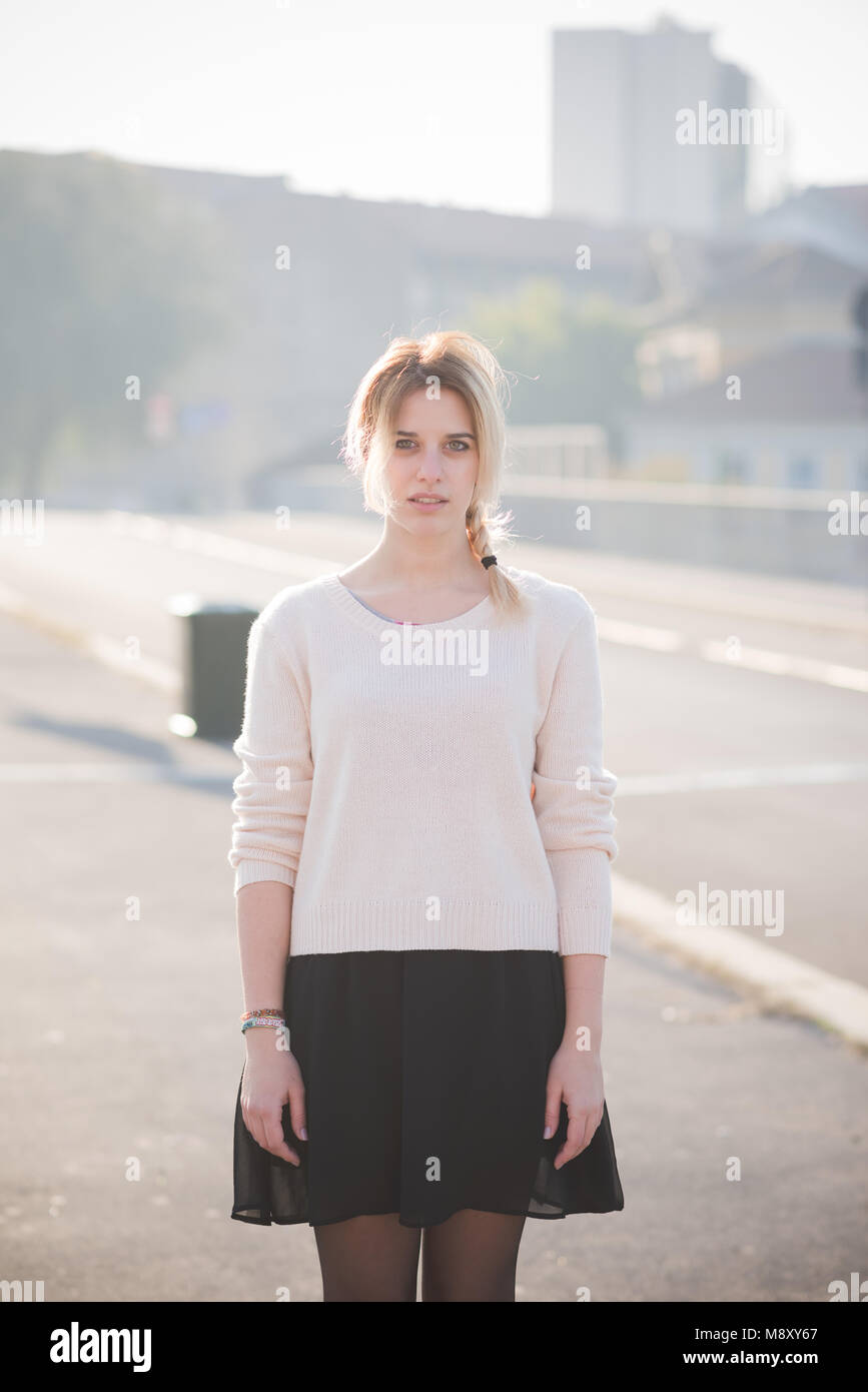 young woman outdoor back light posing looking camera smiling - serene ...
