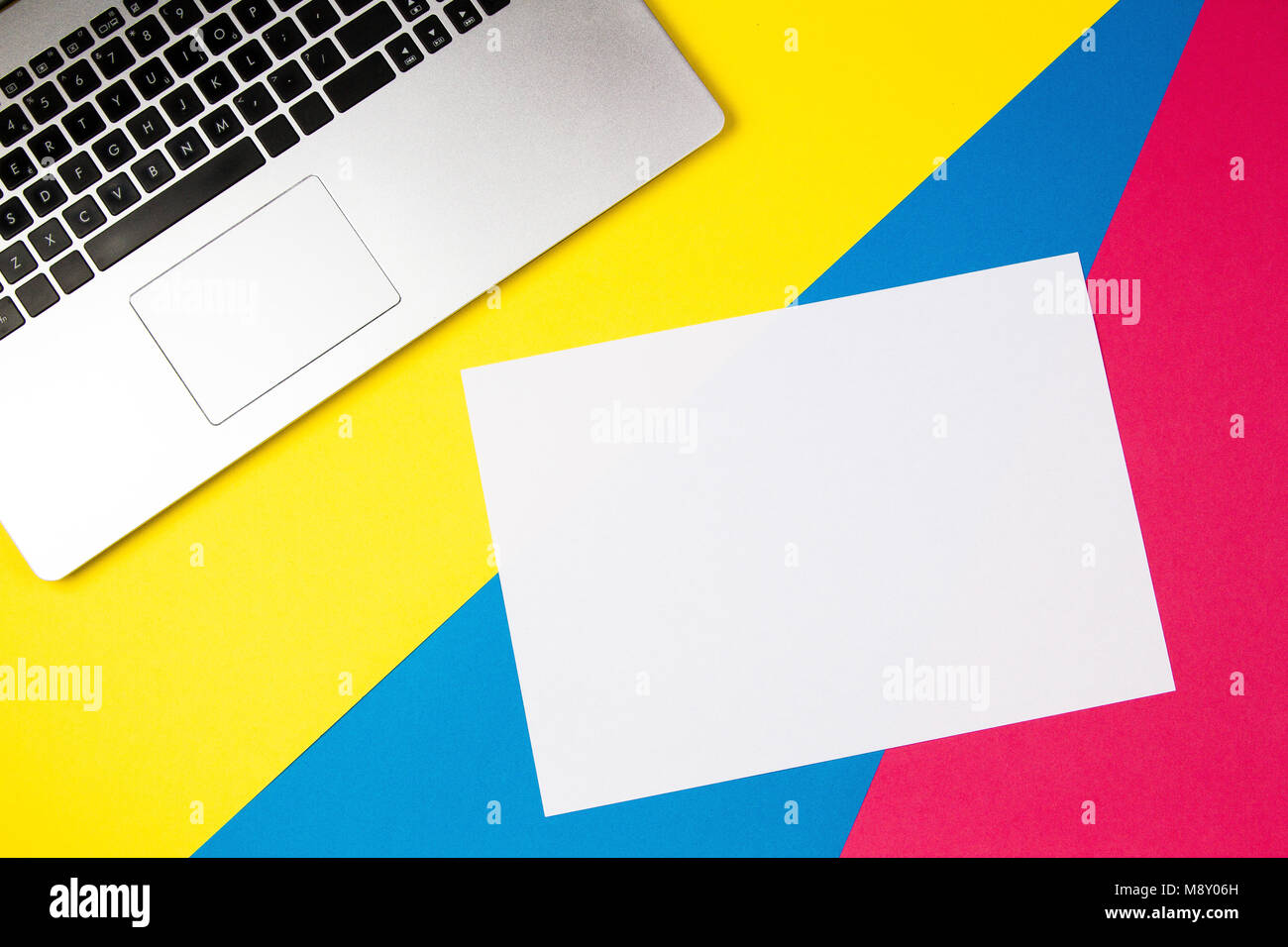 Top view of laptop computer and blank sheet of paper on colorful ...