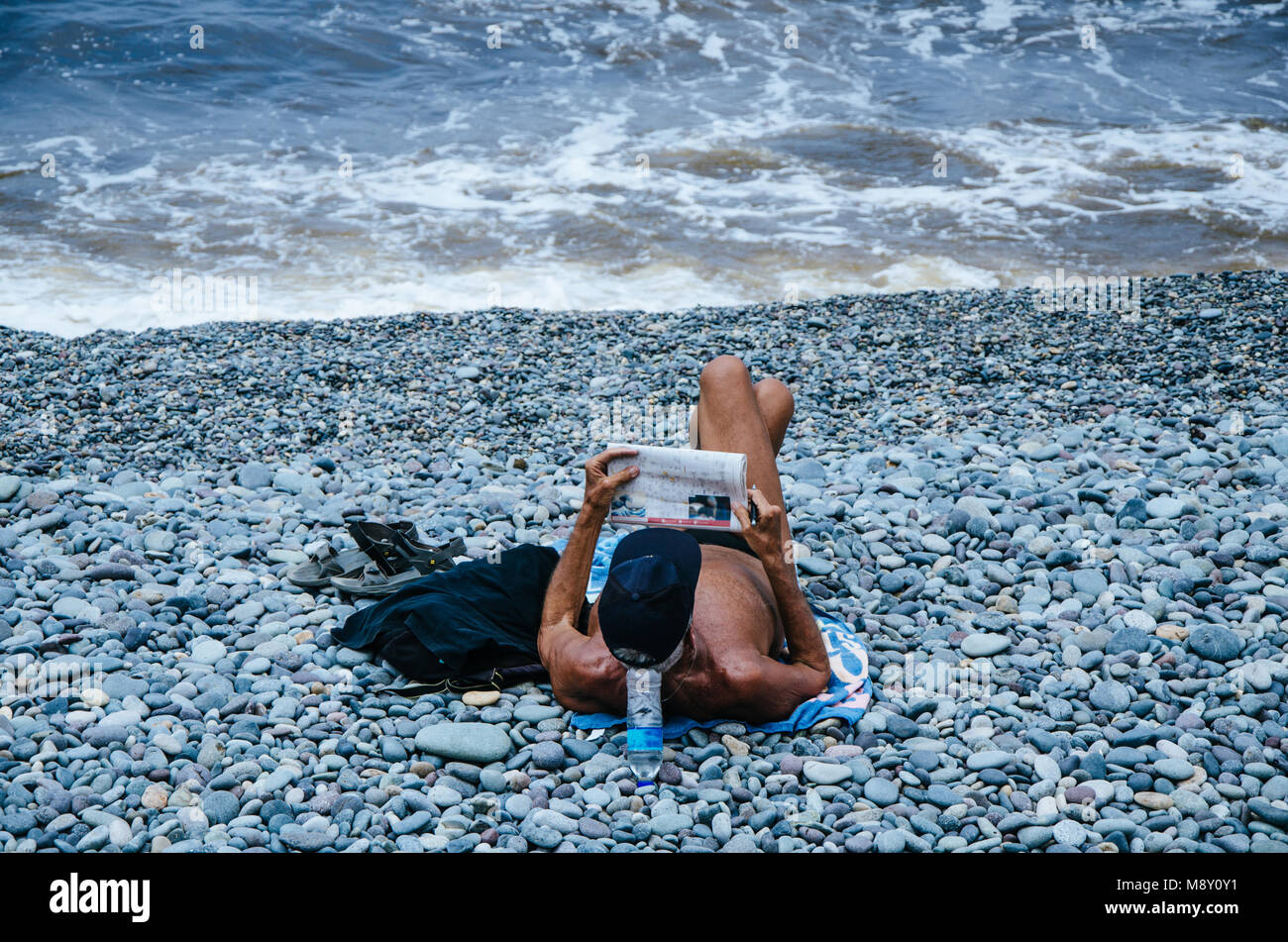 Man reading the newspaper on the beach and enjoying the summer Stock ...