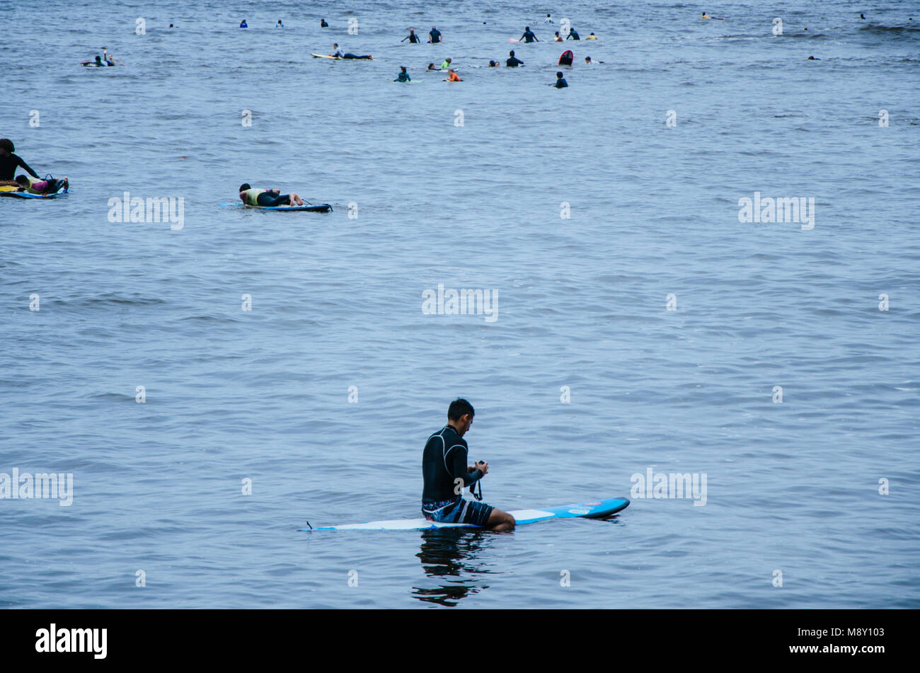 Surfer resting on his board in the sea Stock Photo - Alamy