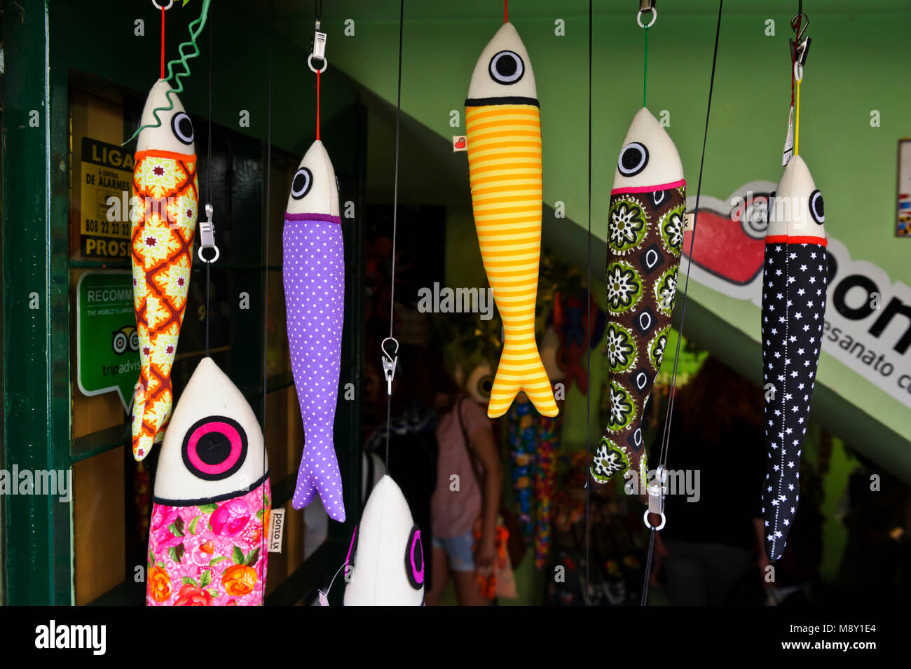 Colourful decorative fish hanging in the doorway of a shop, Lisbon ...