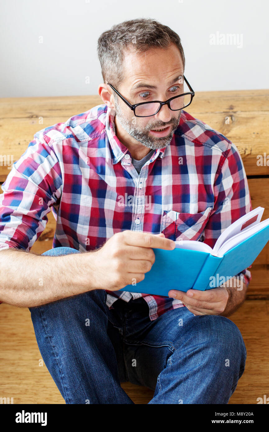portrait of handsome bearded man reading a book Stock Photo - Alamy