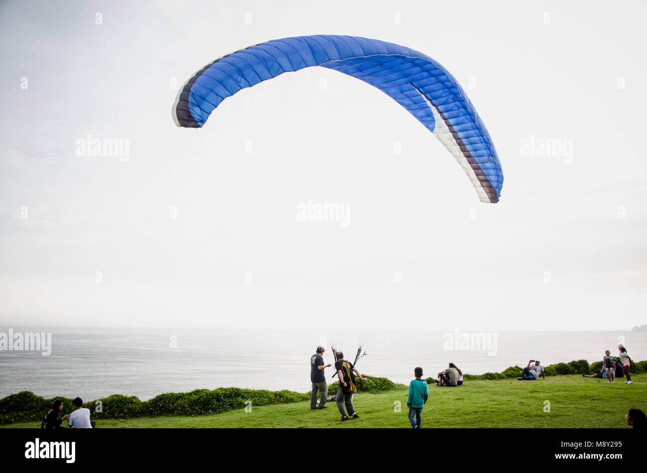 Man opening his paraglider to the edge of the cliff Stock Photo - Alamy