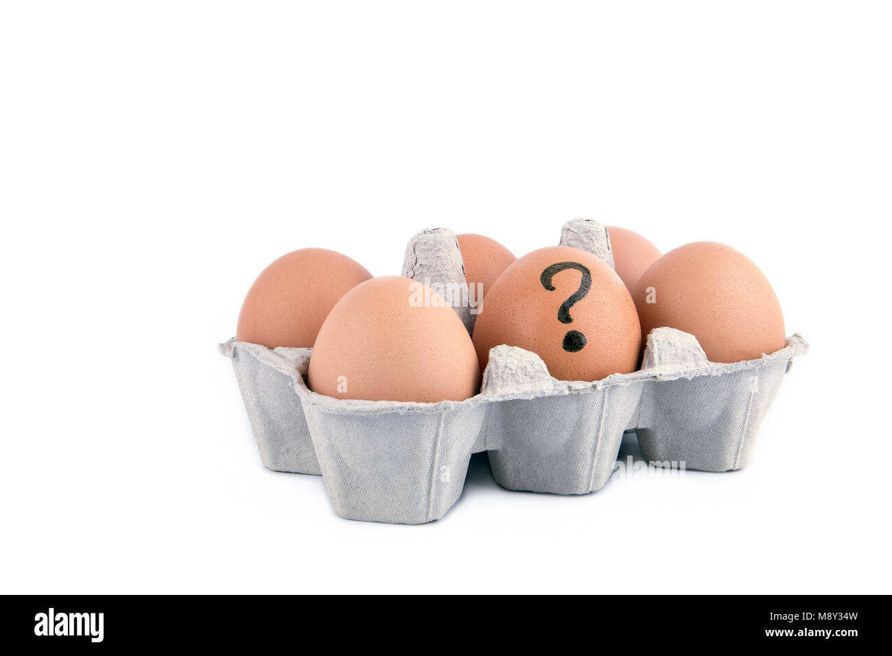 Close-up view of raw chicken eggs with question mark in box on white ...