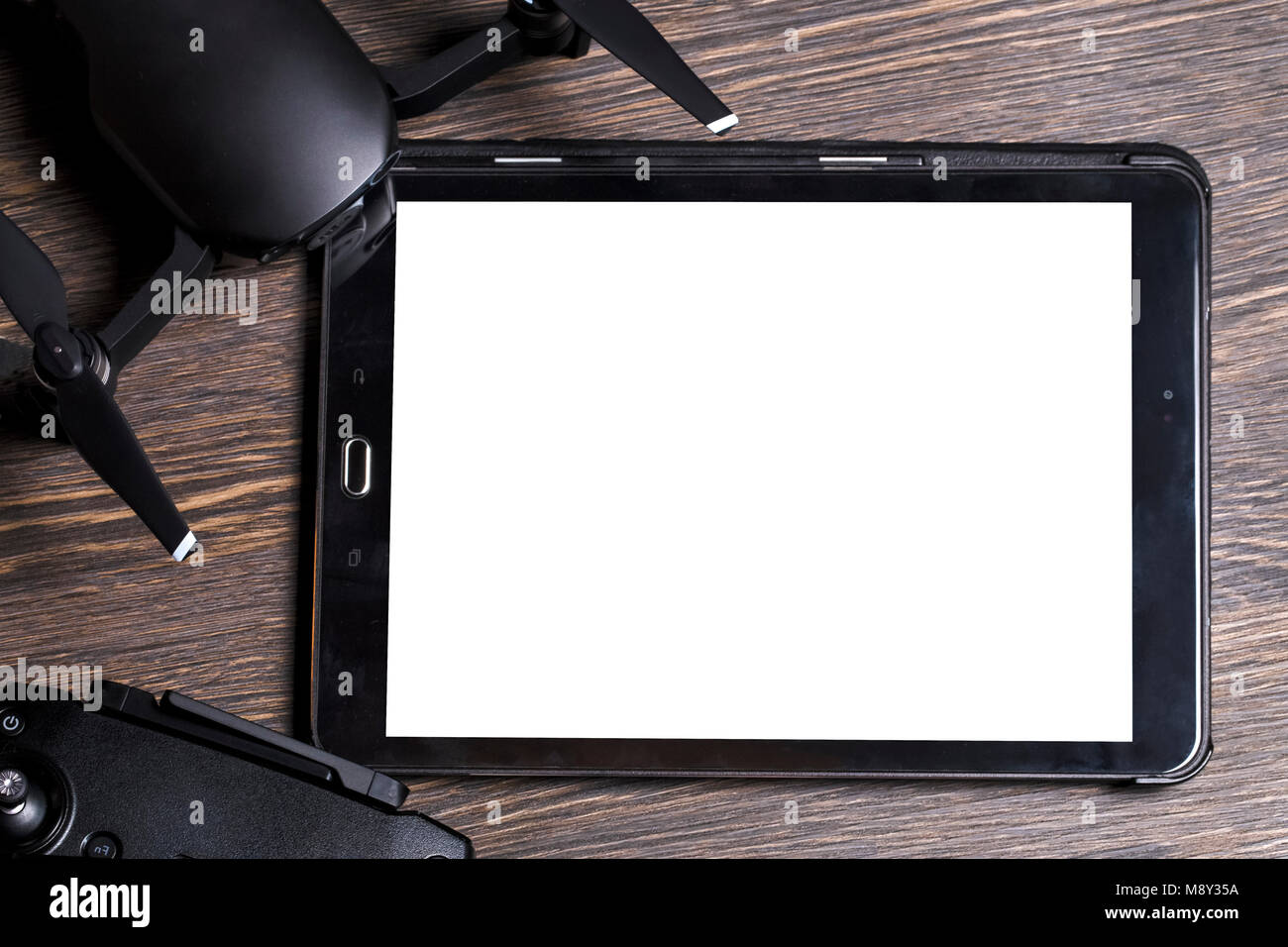 drone tablet and remote control, on a wooden background, in the middle ...