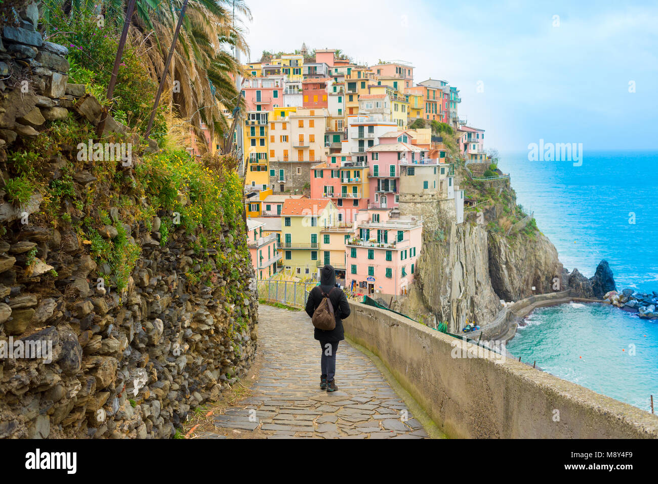 Woman walking on a path with view on the small traditional Italian ...